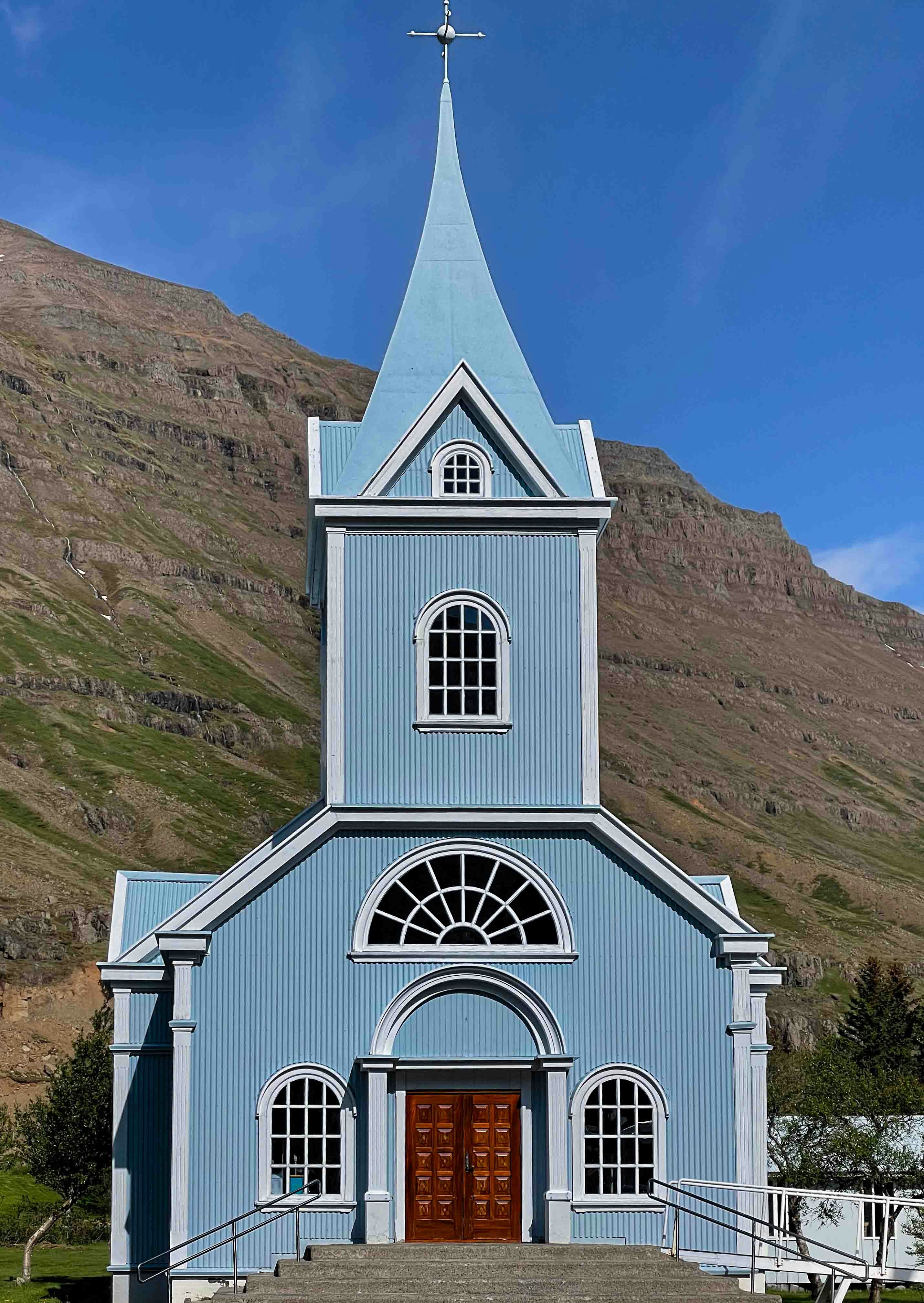 A blue church with a steeple and a cross on top photo – Free Island ...