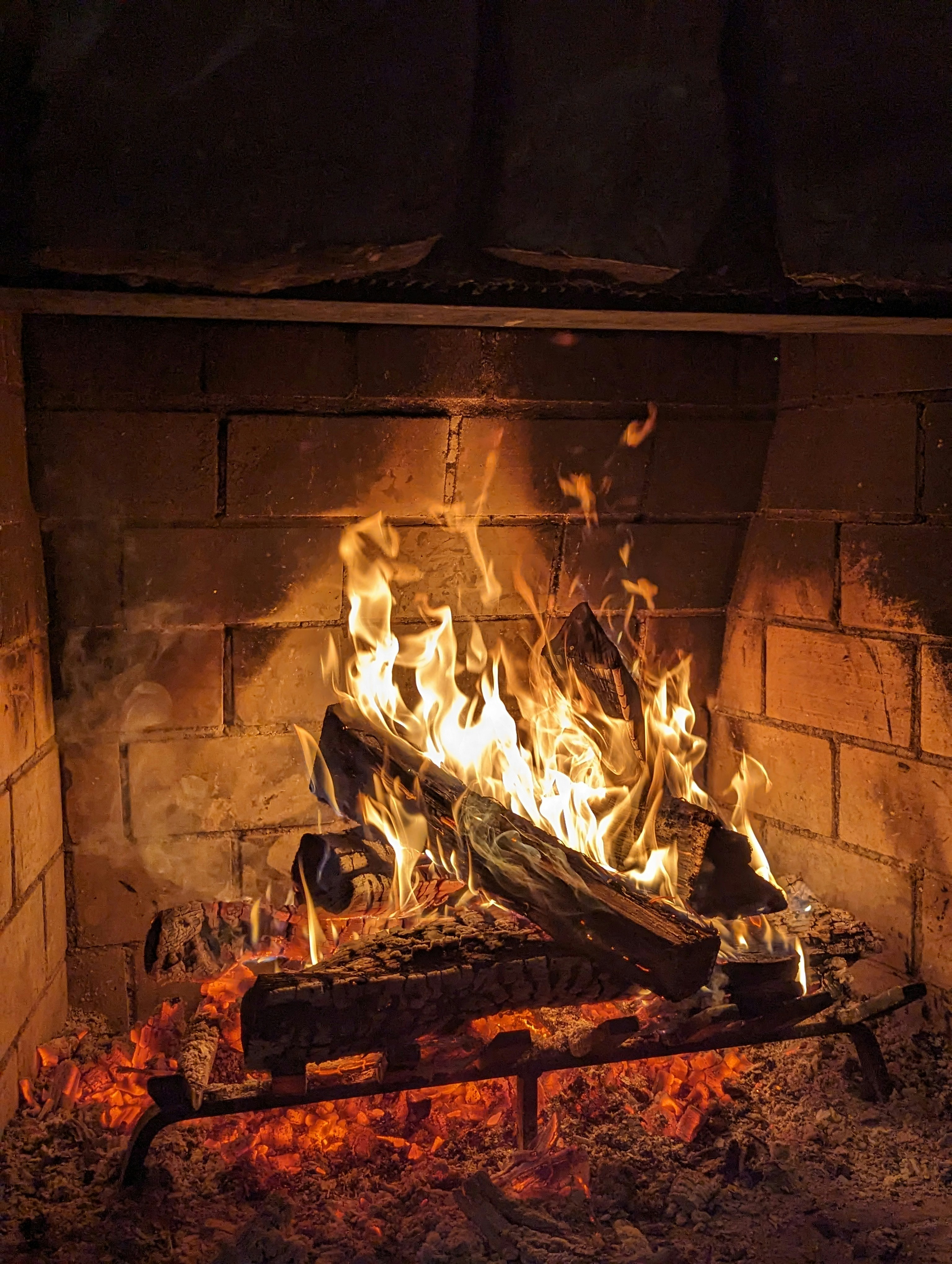 A fire burning inside of a brick fireplace photo – Free Fireplace Image ...
