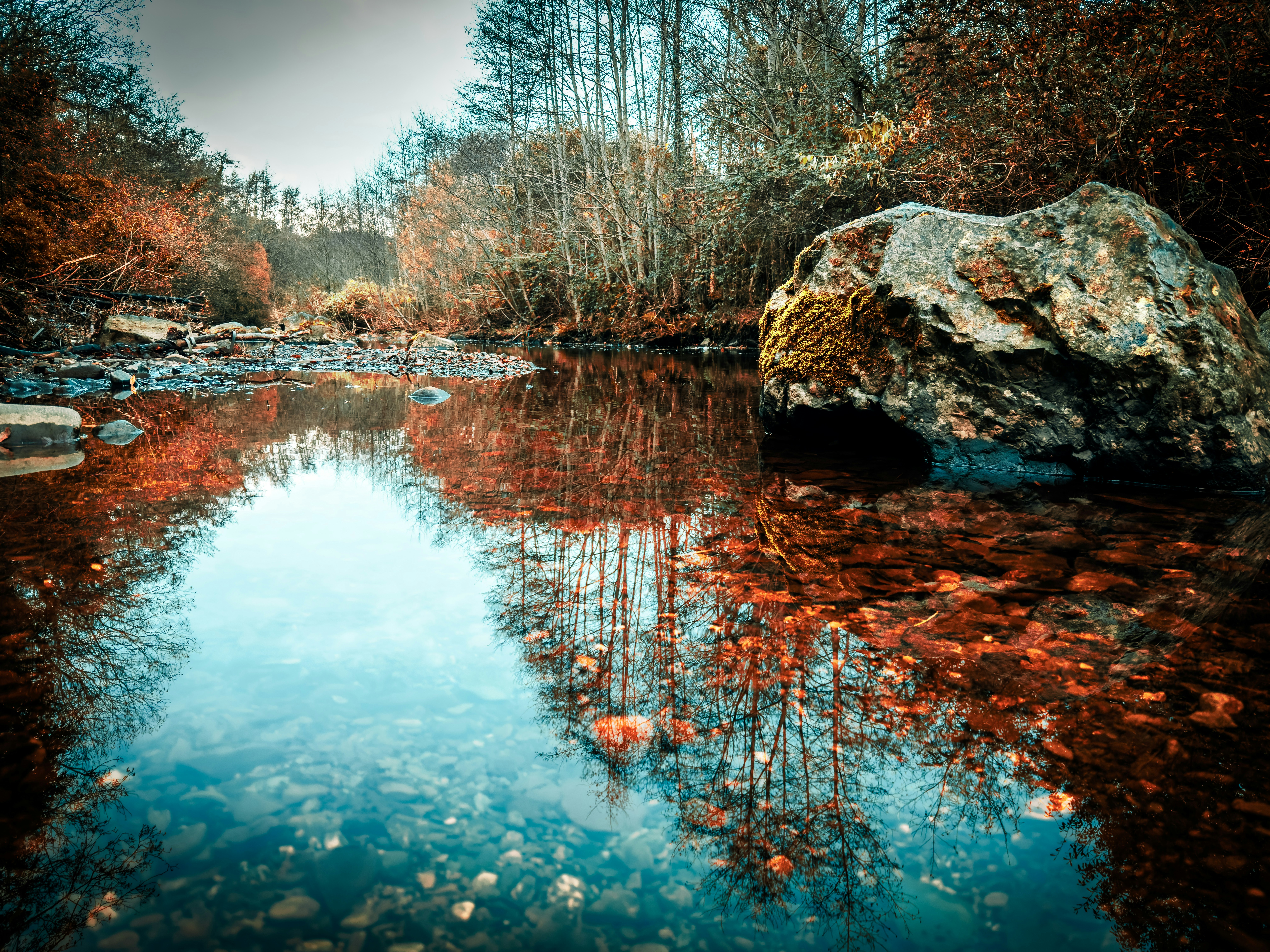 Rock Sentinel Over a River of Autumn Reflections