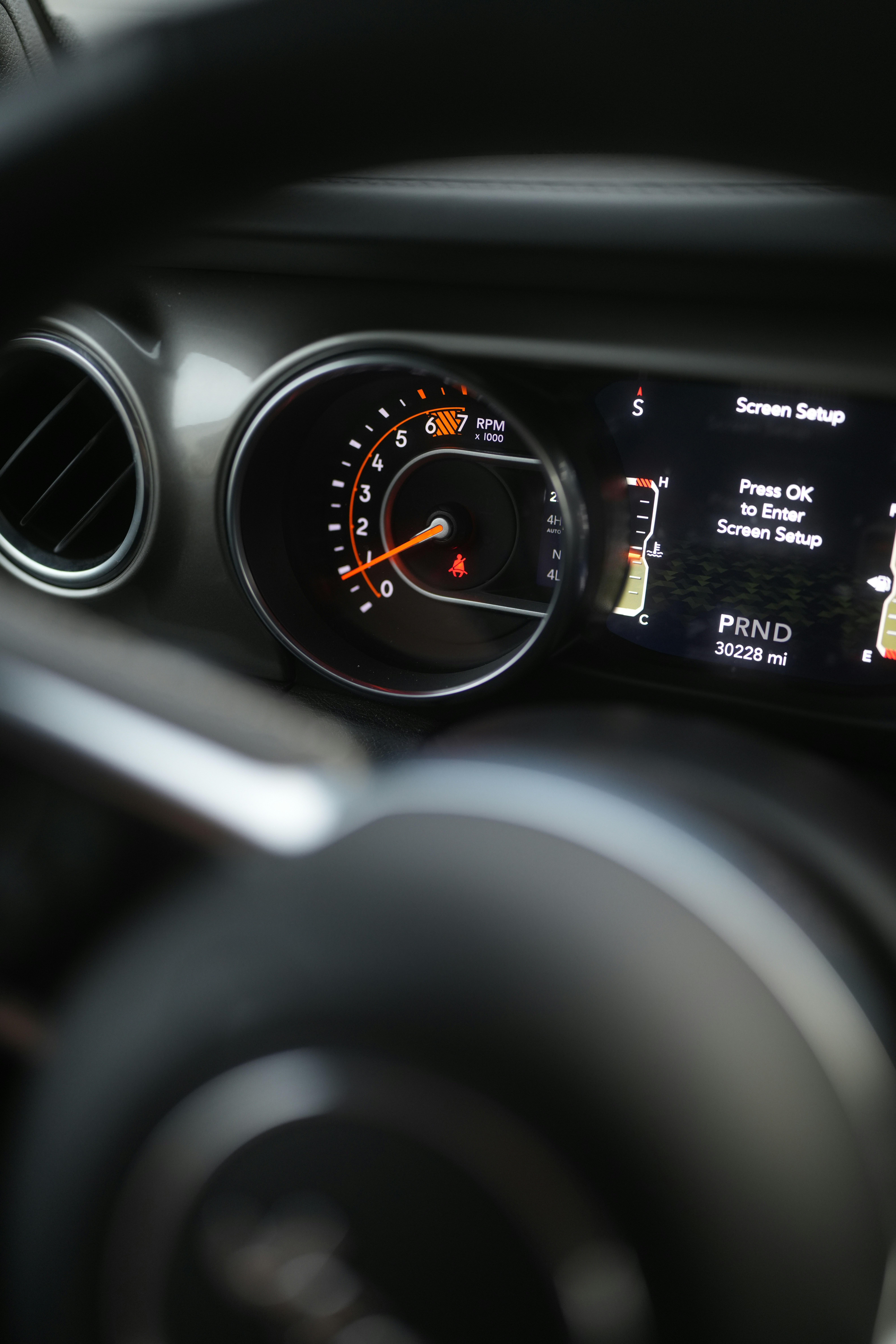 Close-up of a vehicle dashboard displaying RPM and mileage, highlighting the intricate details of automotive instrumentation.