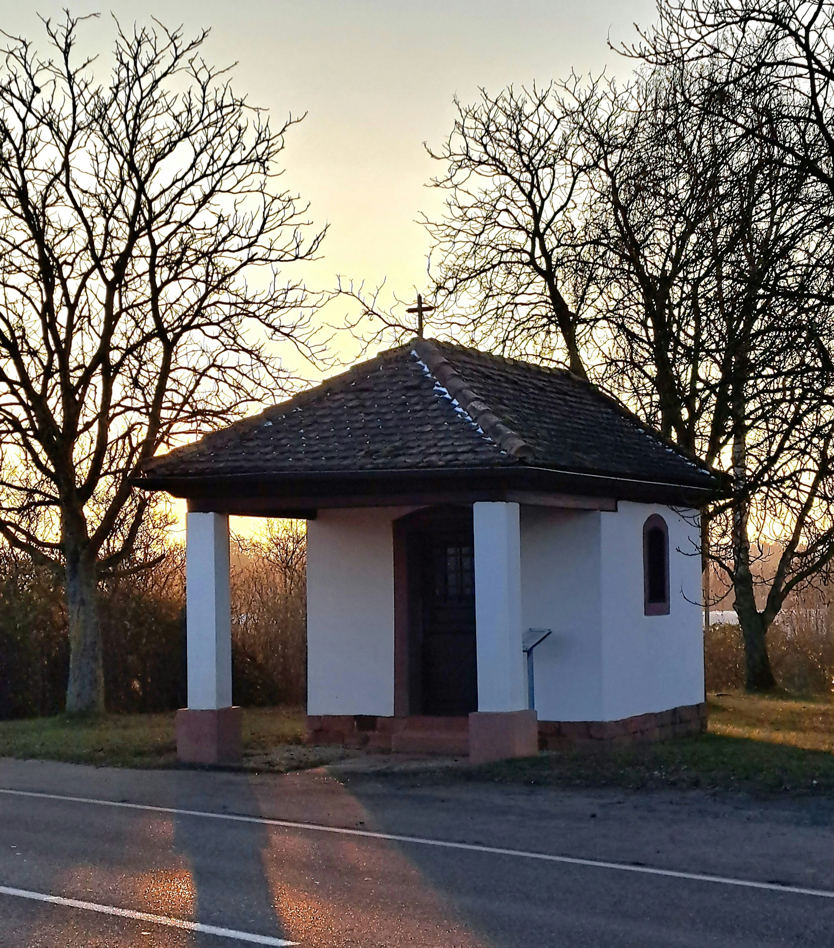 A small white building sitting on the side of a road photo – Free House ...