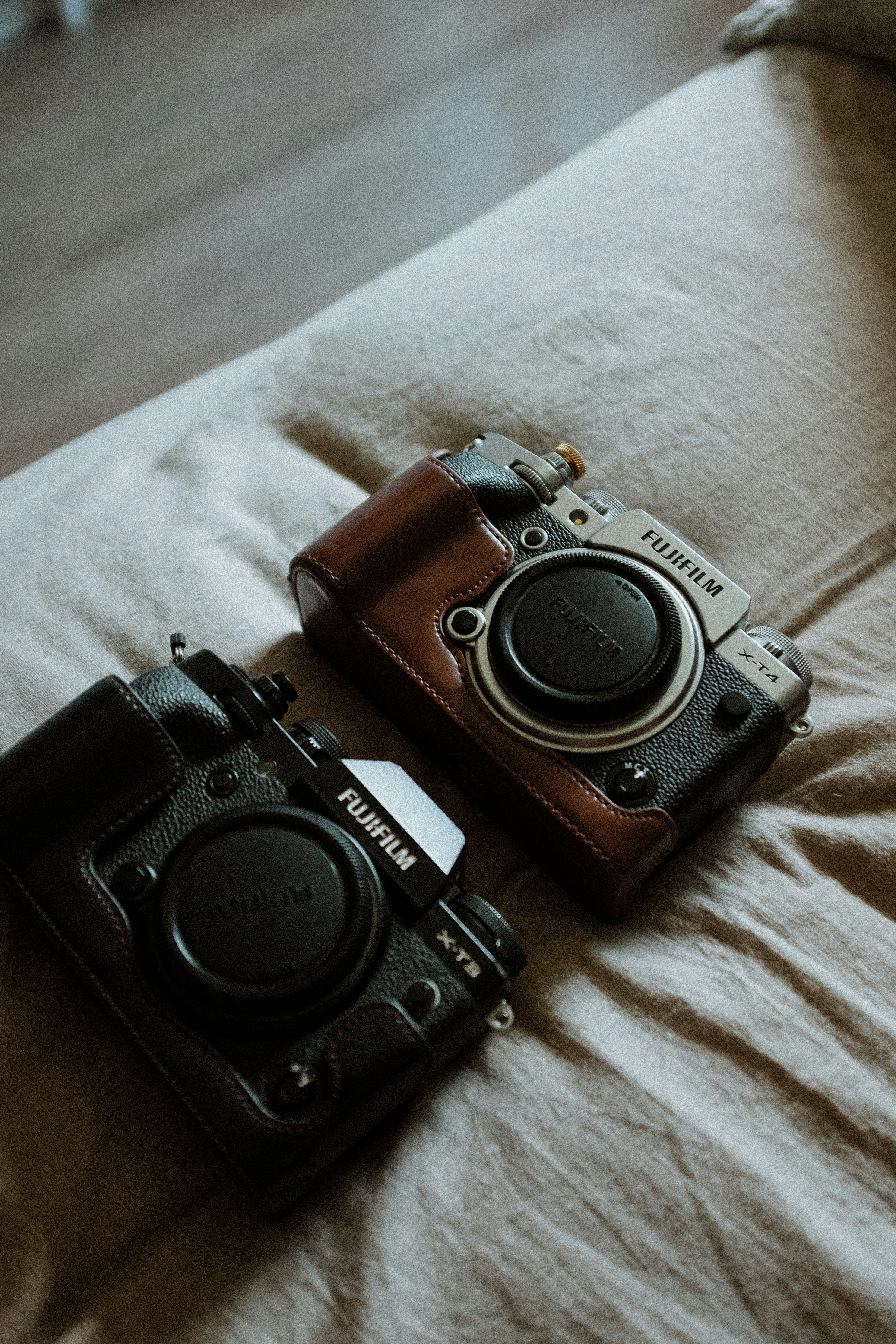 A couple of cameras sitting on top of a bed photo – Free Brasil Image ...