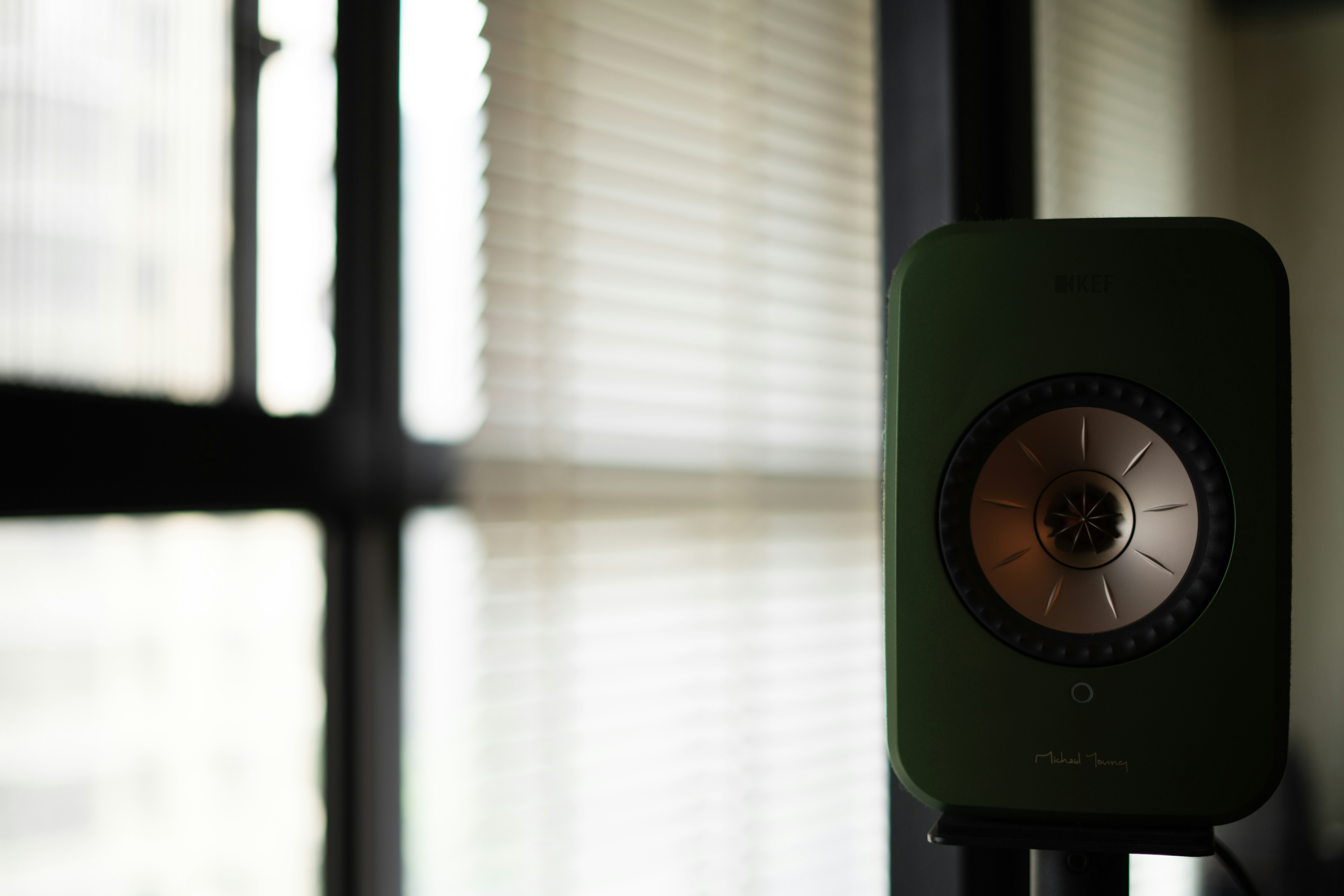 Stylish speaker showcased against a backdrop of sunlit blinds, emphasizing modern aesthetics and functionality.