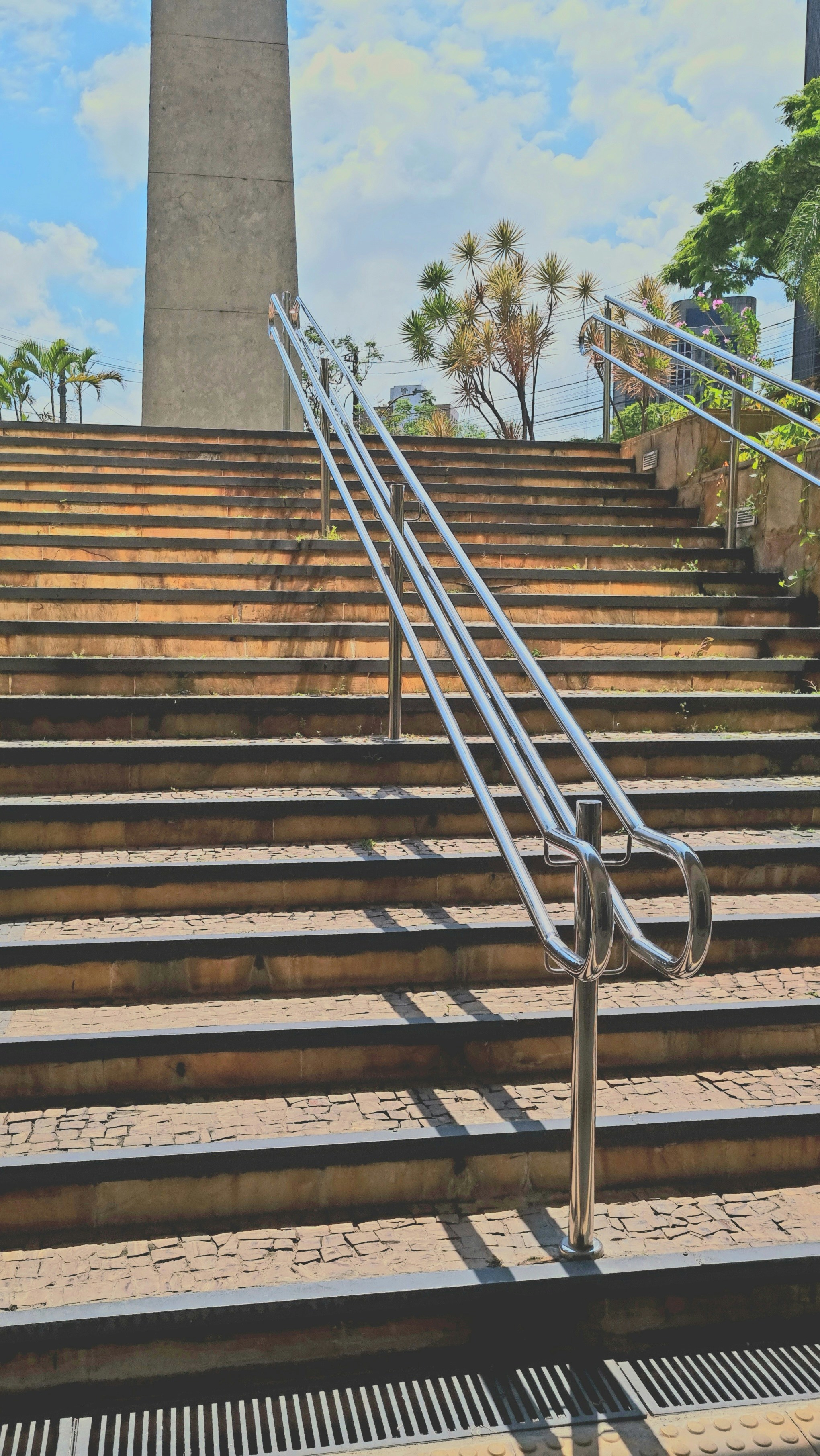 Sunlit Ascent: Shiny Handrails Line the Staircase to the Sky