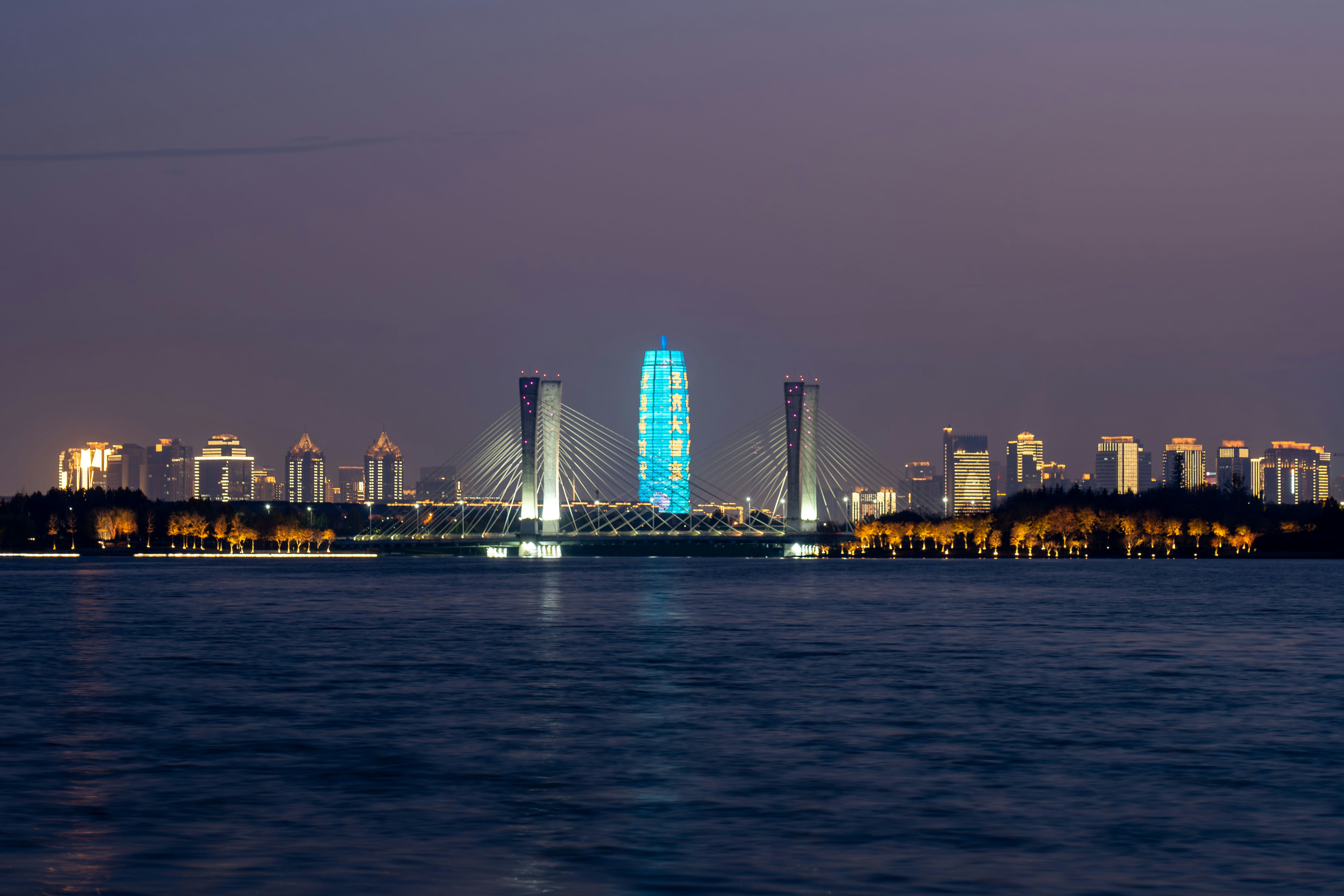 Azure Beacon Over the River: The Central Blue Tower Anchoring a Nighttime Skyline