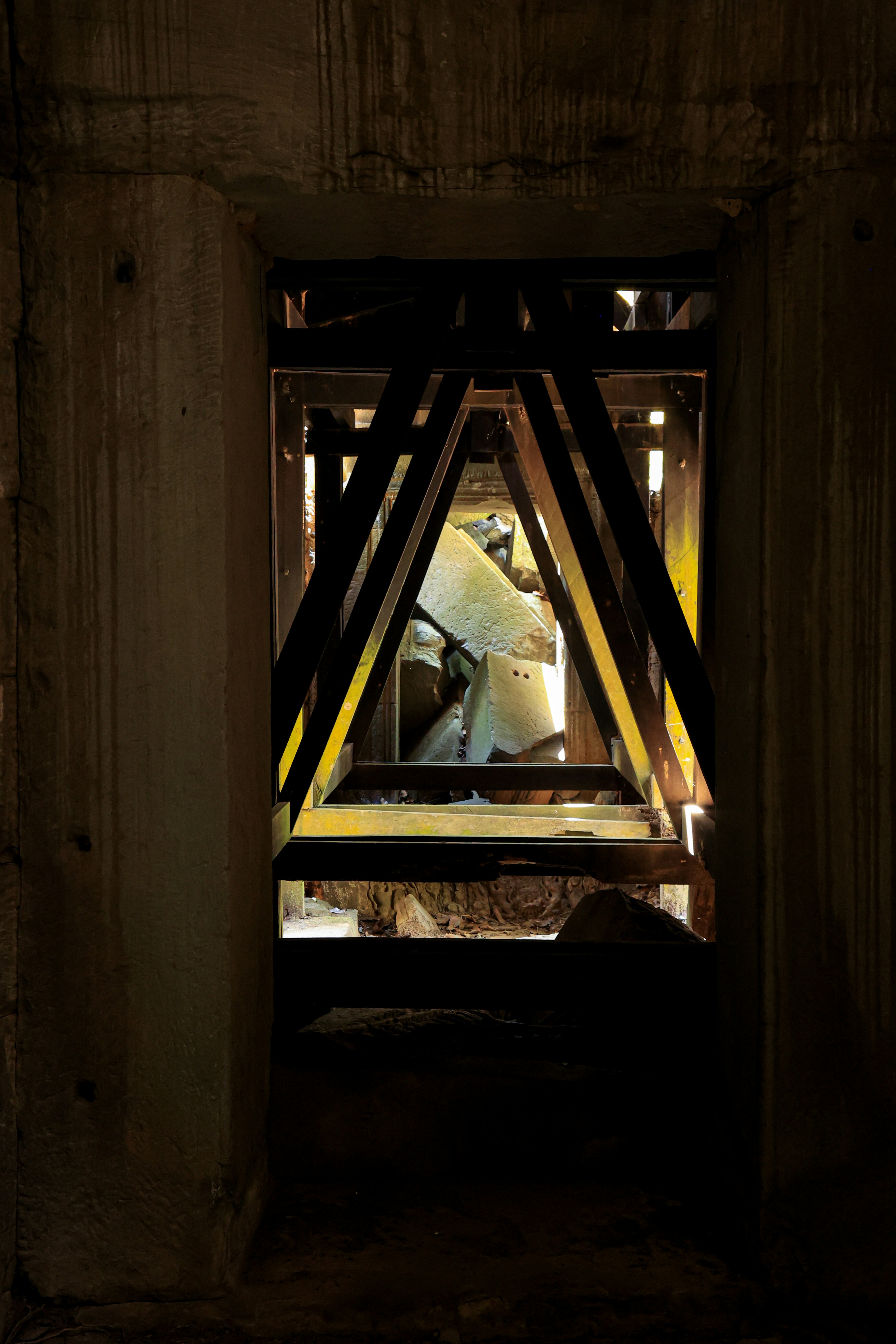 A view of a clock tower through a hole in the wall photo – Free Angkor ...
