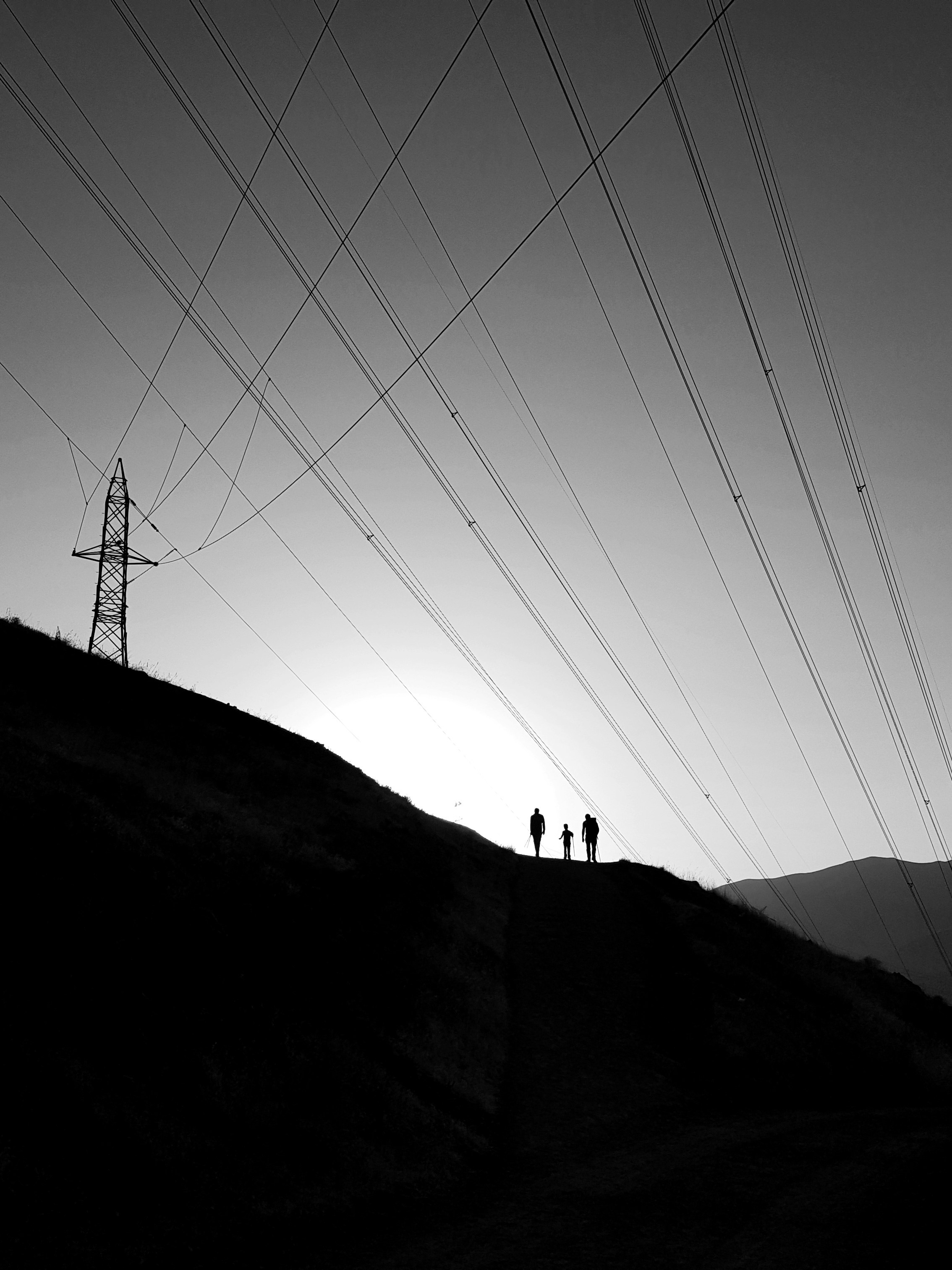 Ridgeline Silhouettes: Hikers Beneath a Web of Power Lines