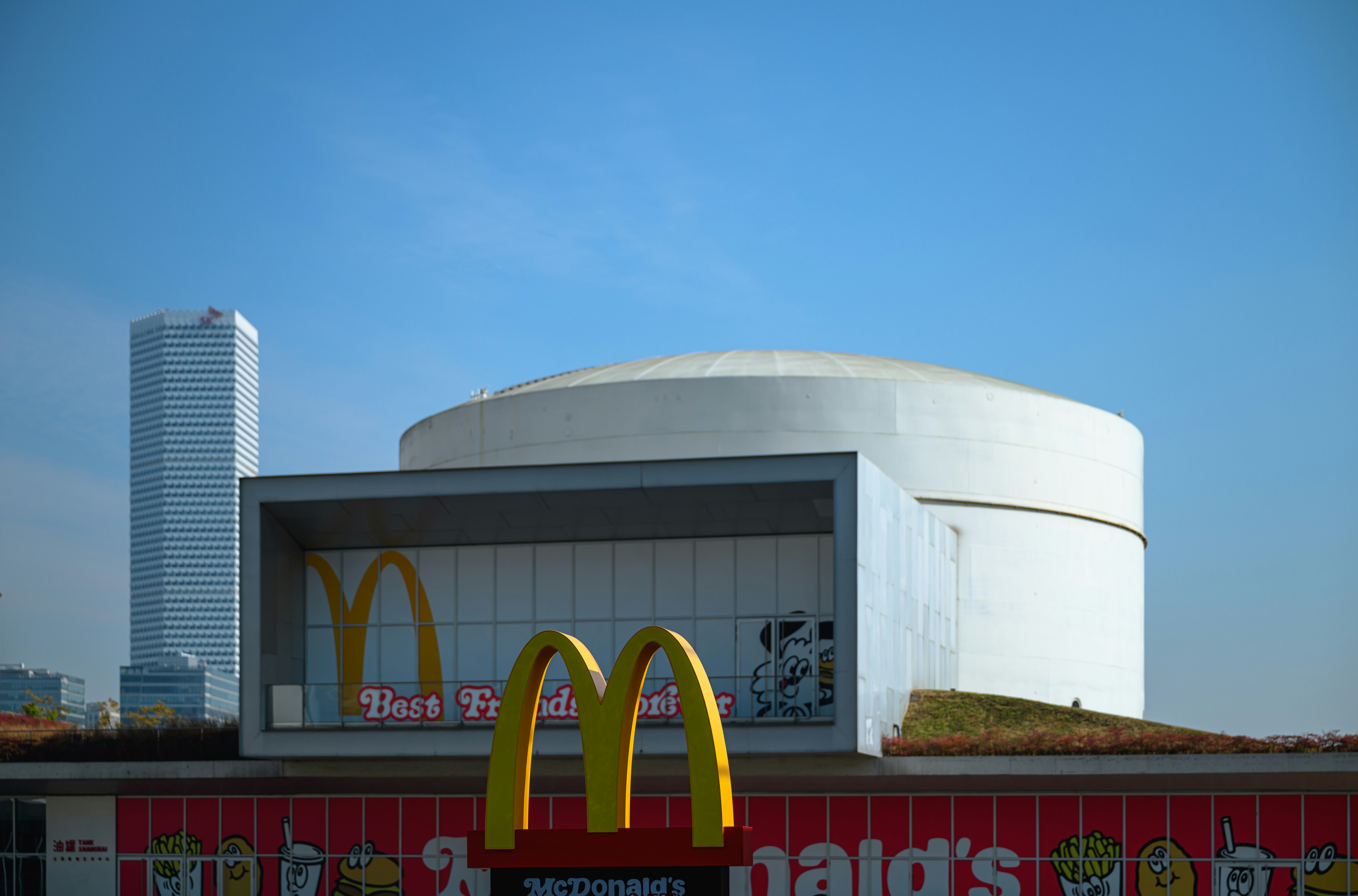 Golden Arches Framed by a Circular White Dome Under a Clear Blue Sky