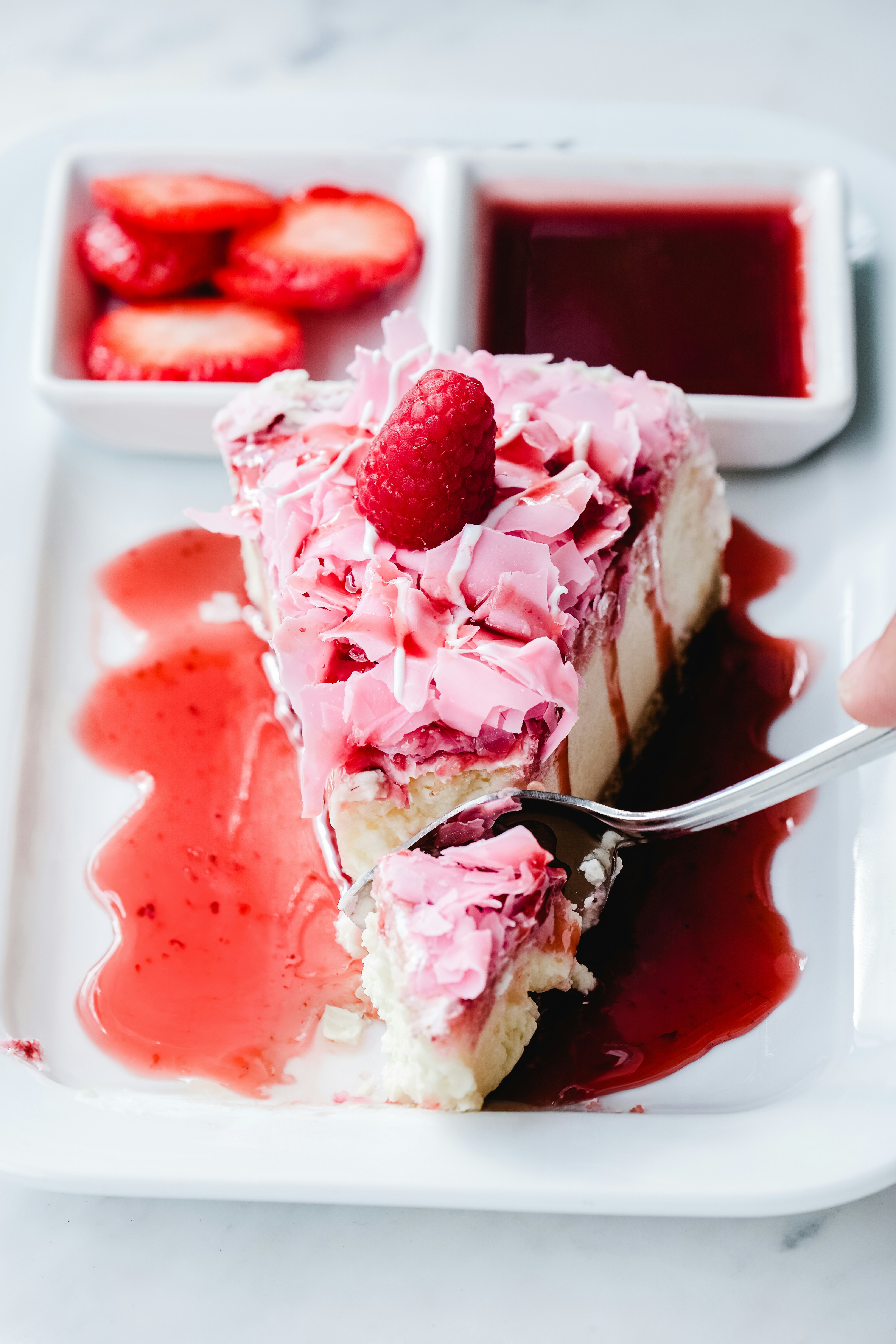 A white plate topped with a piece of cake covered in whipped cream and ...