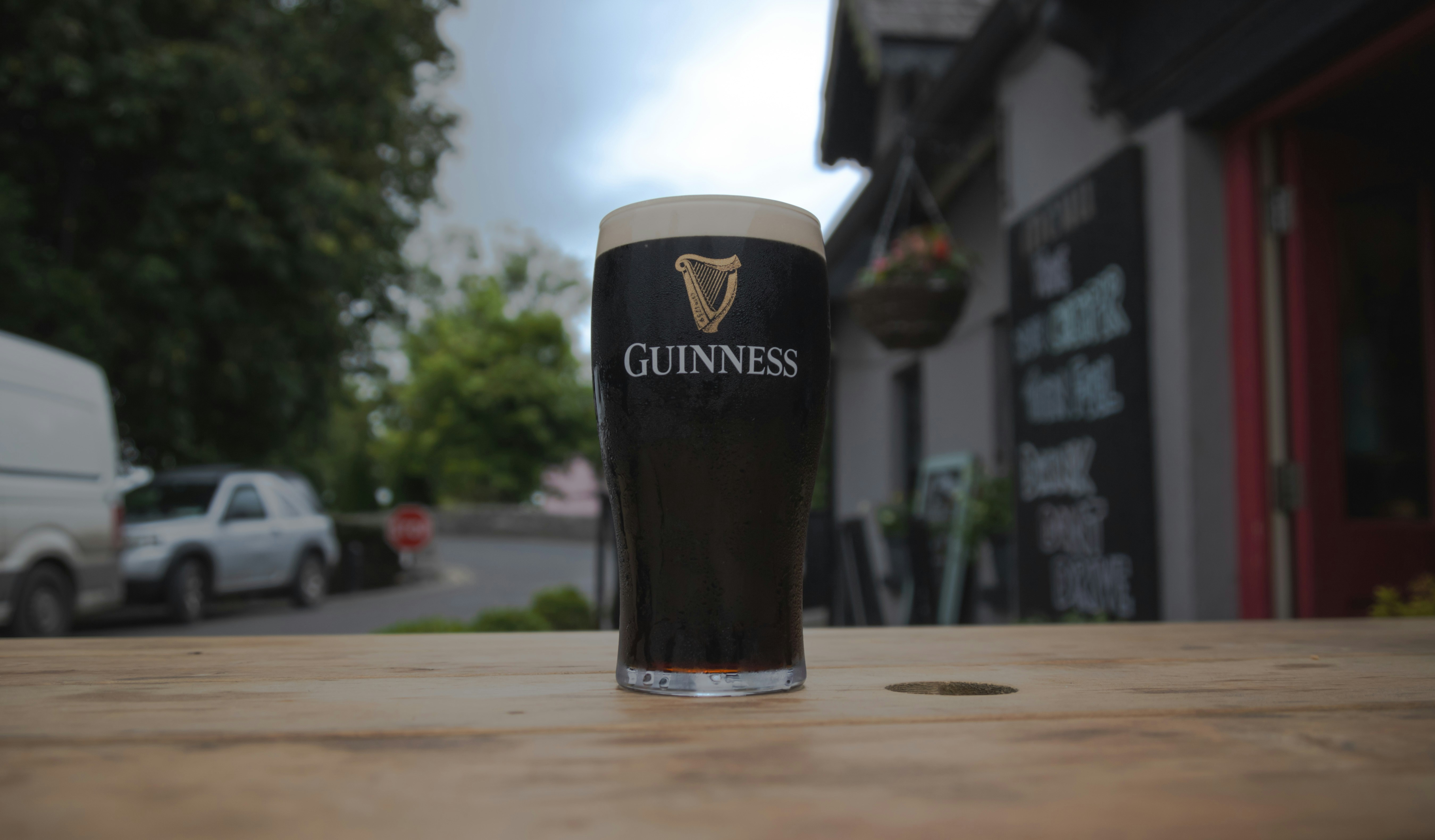 A pint of guinness on a table outside a pub photo – Free Ireland Image ...