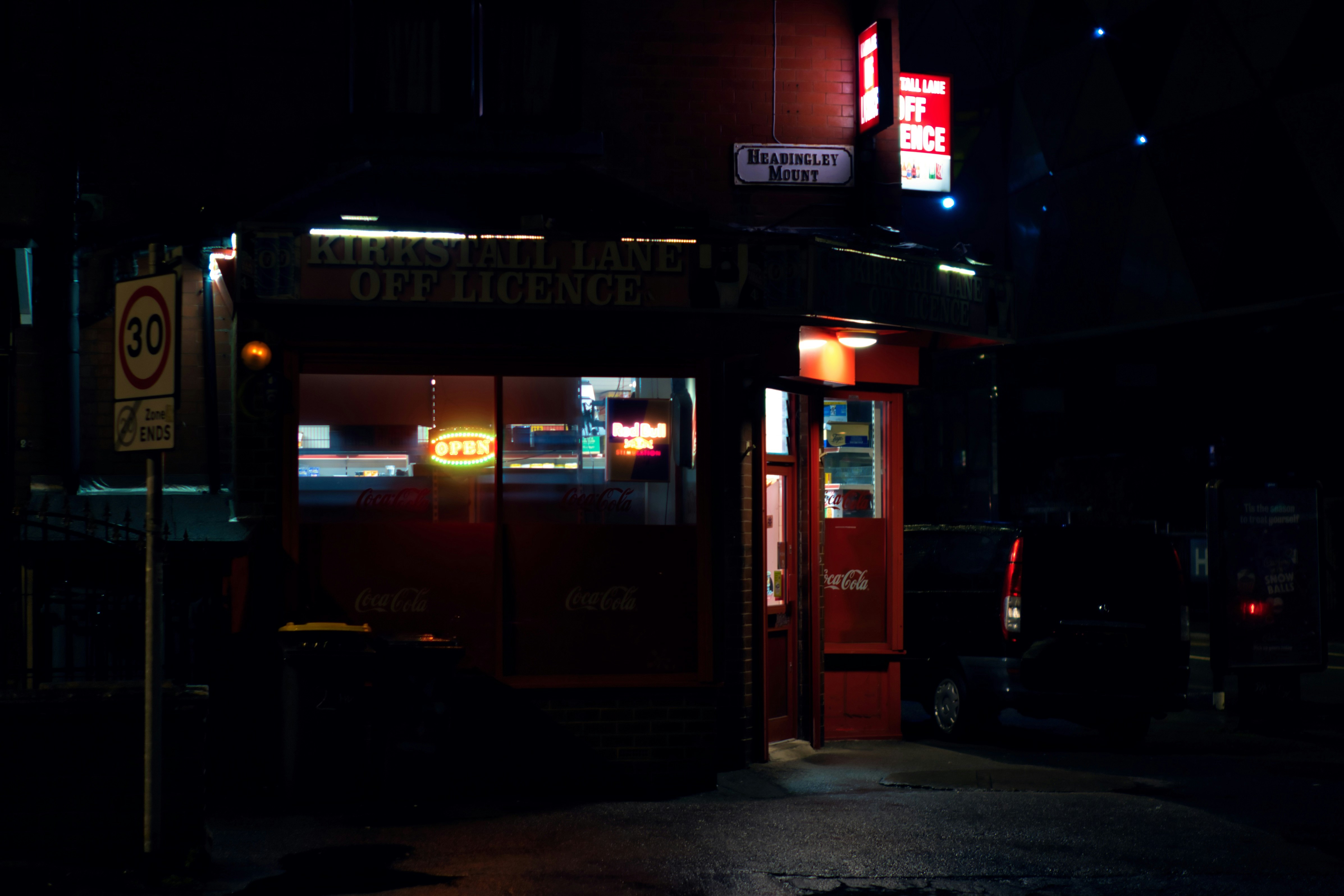 The red glow of the signs at this corner shop in England really stands out against the darkness of the night.