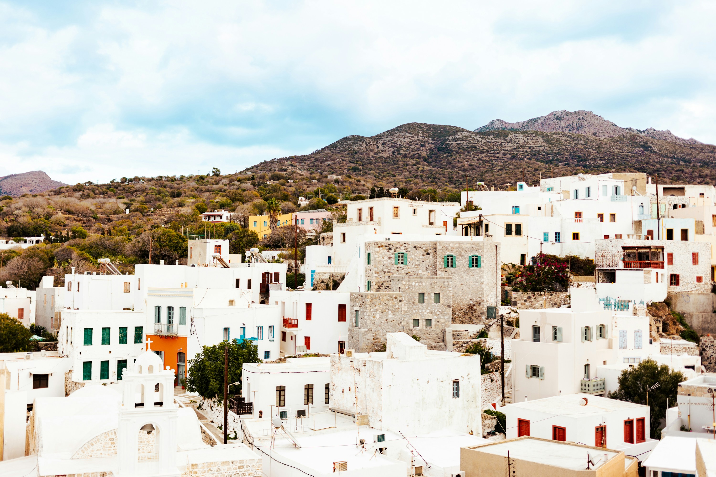 A city with white buildings and mountains in the background photo ...