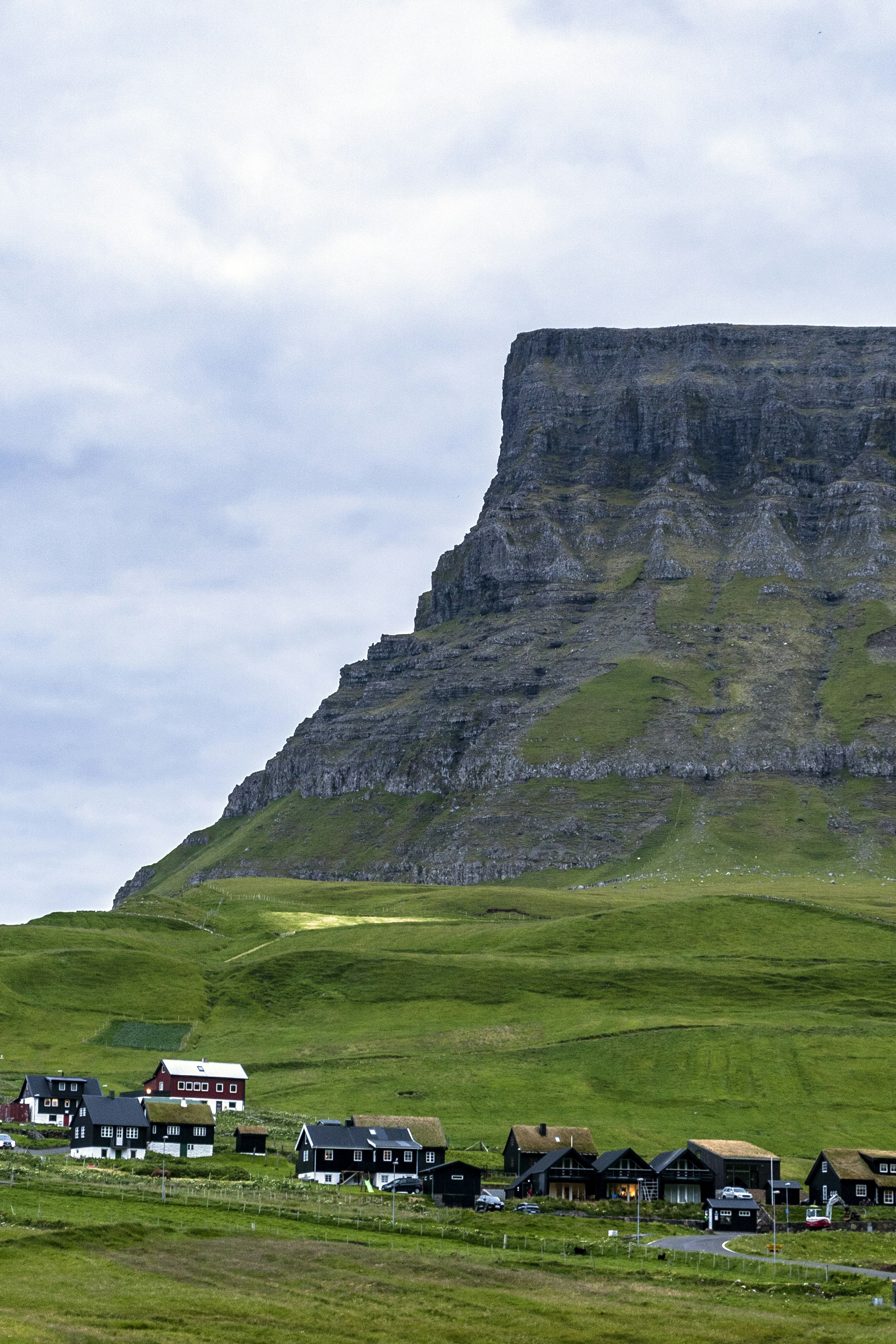 Edge Over Green: A Rugged Mesa Looms Above a Quiet Village