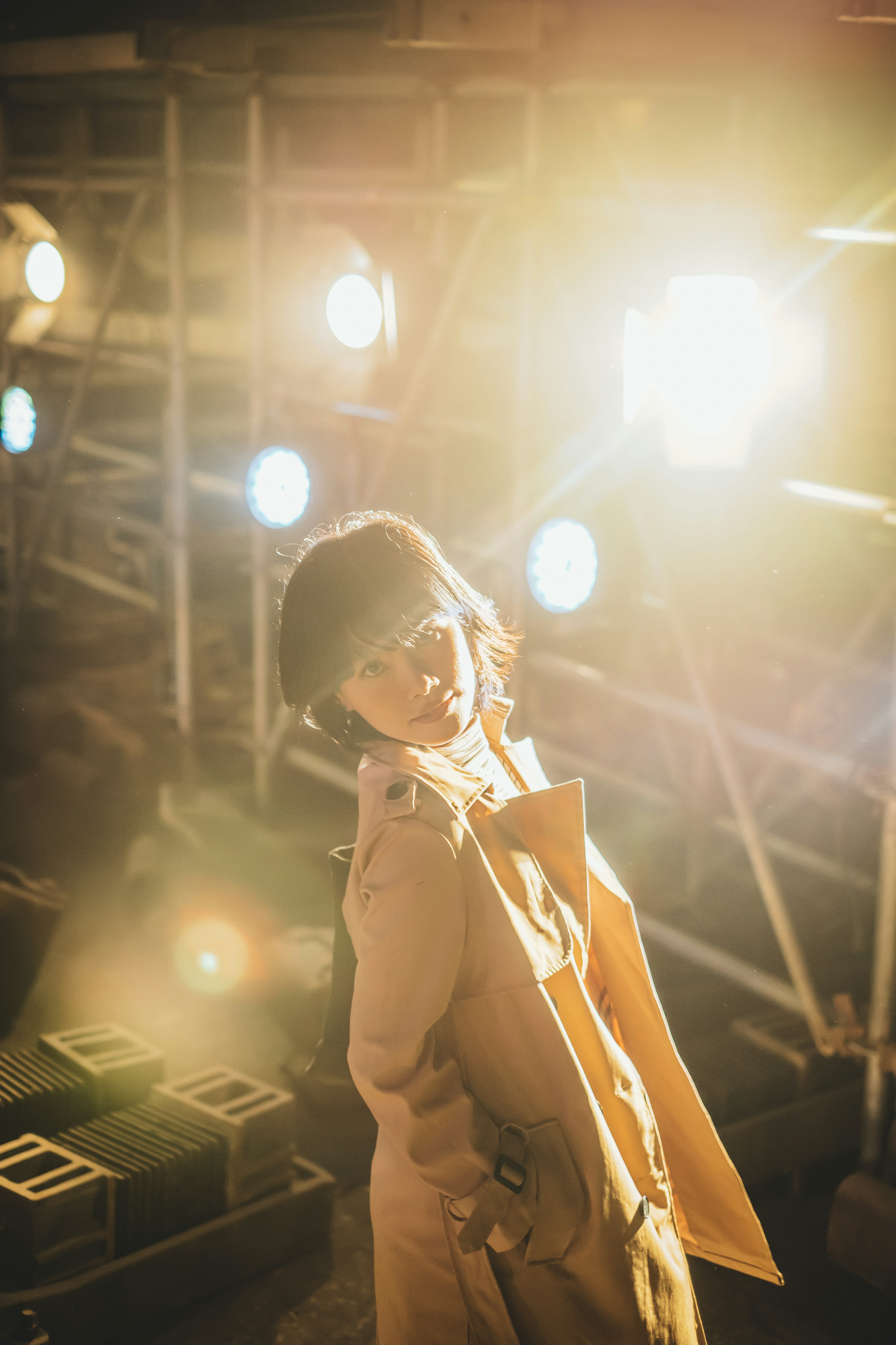 A woman in a trench coat standing in front of a stage photo – Free ...