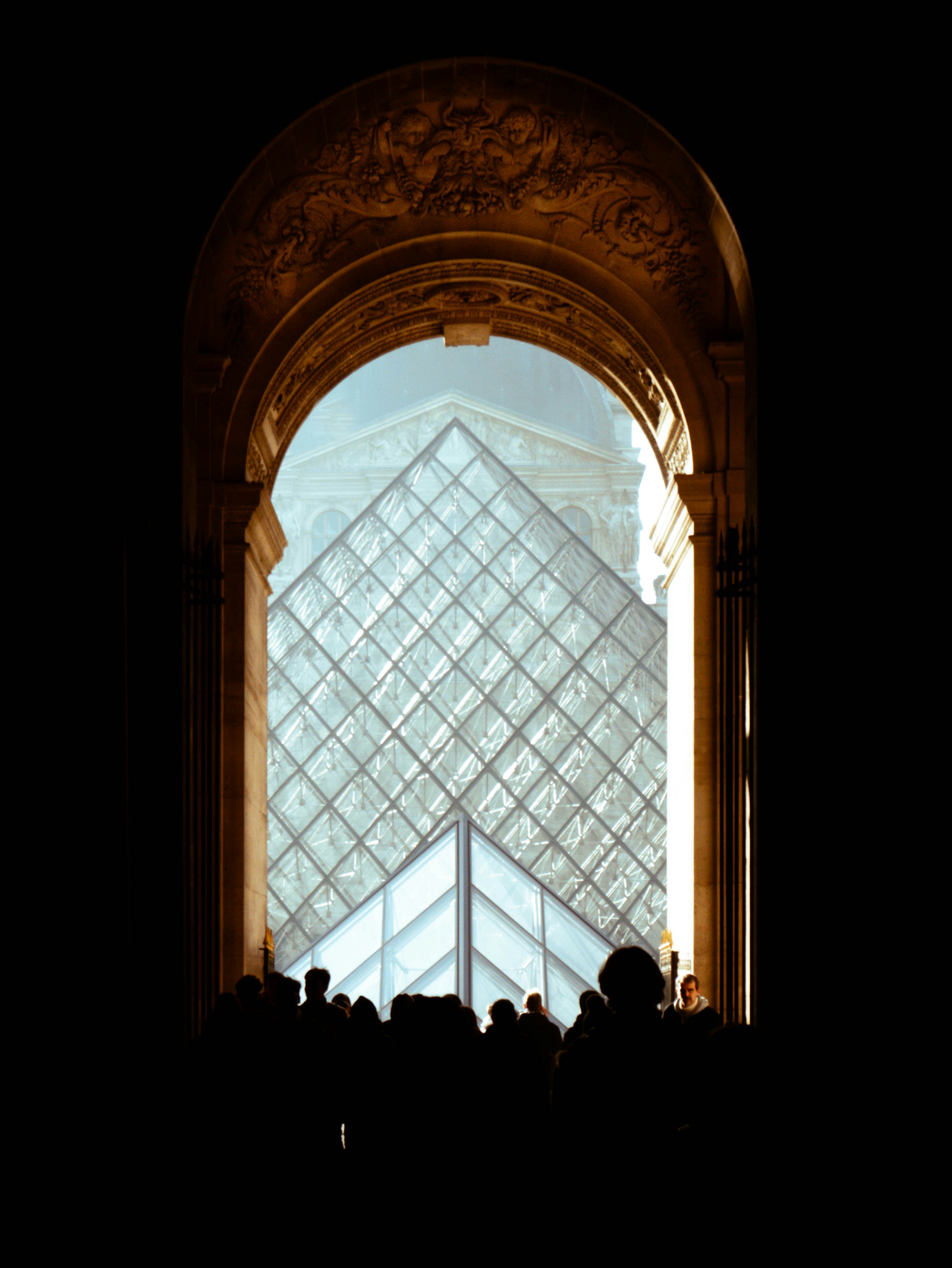 Gazing into the Glass Pyramid: Visitors in the Archway of Louvre