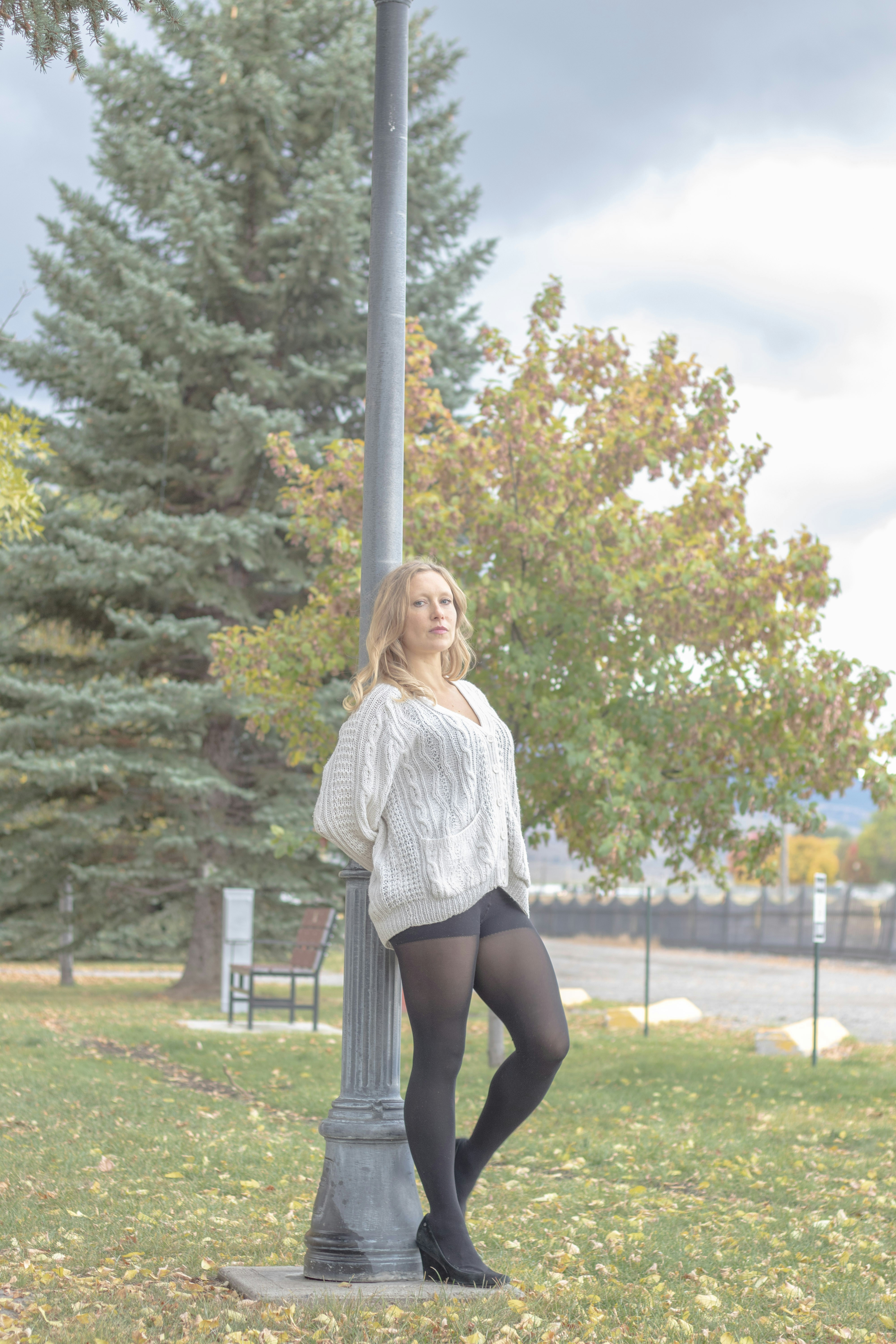 Une femme en collants appuyée contre un lampadaire photo – Image ...