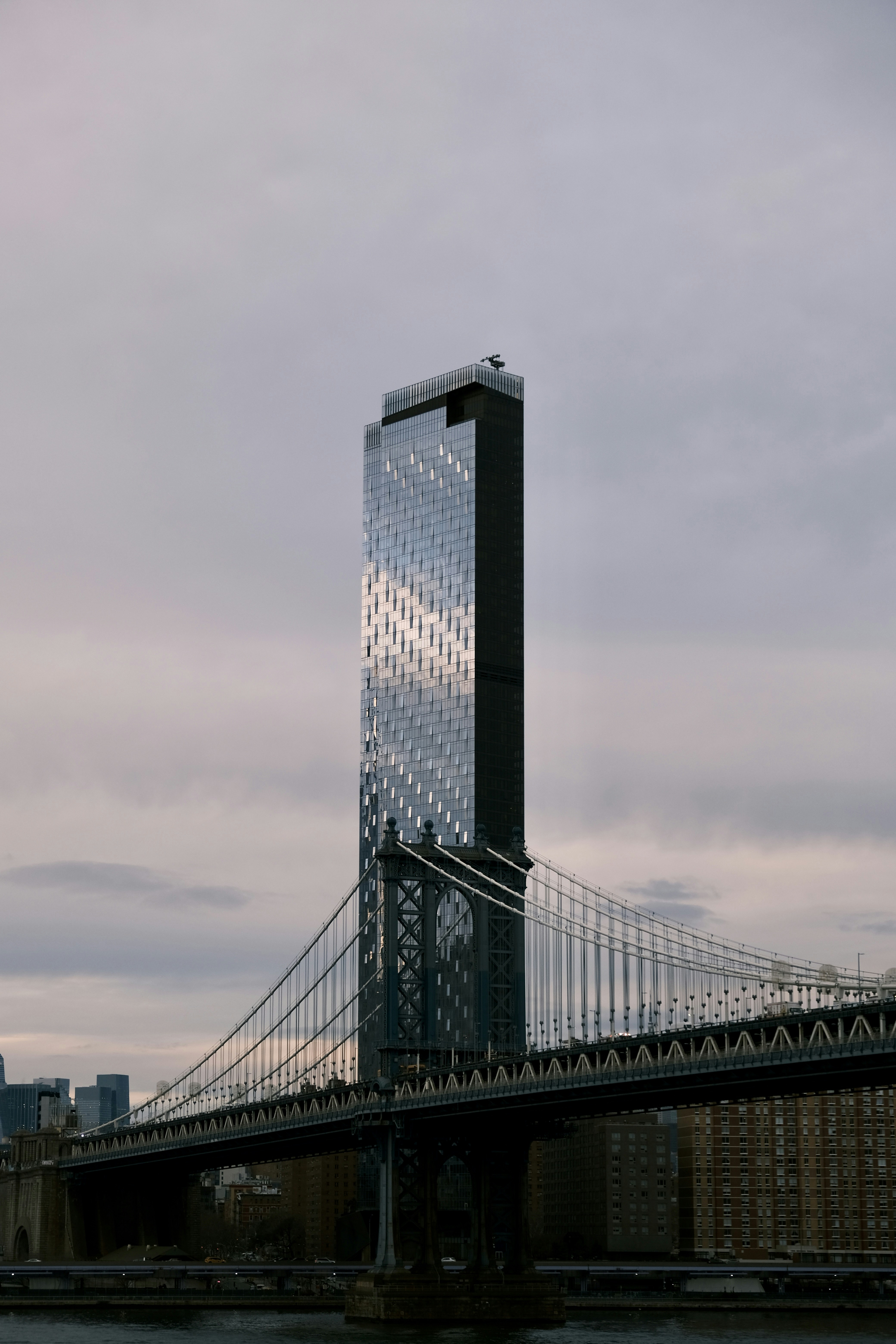 Glass Prism Rising Over a Cable-Span: A Cityscape at Dusk