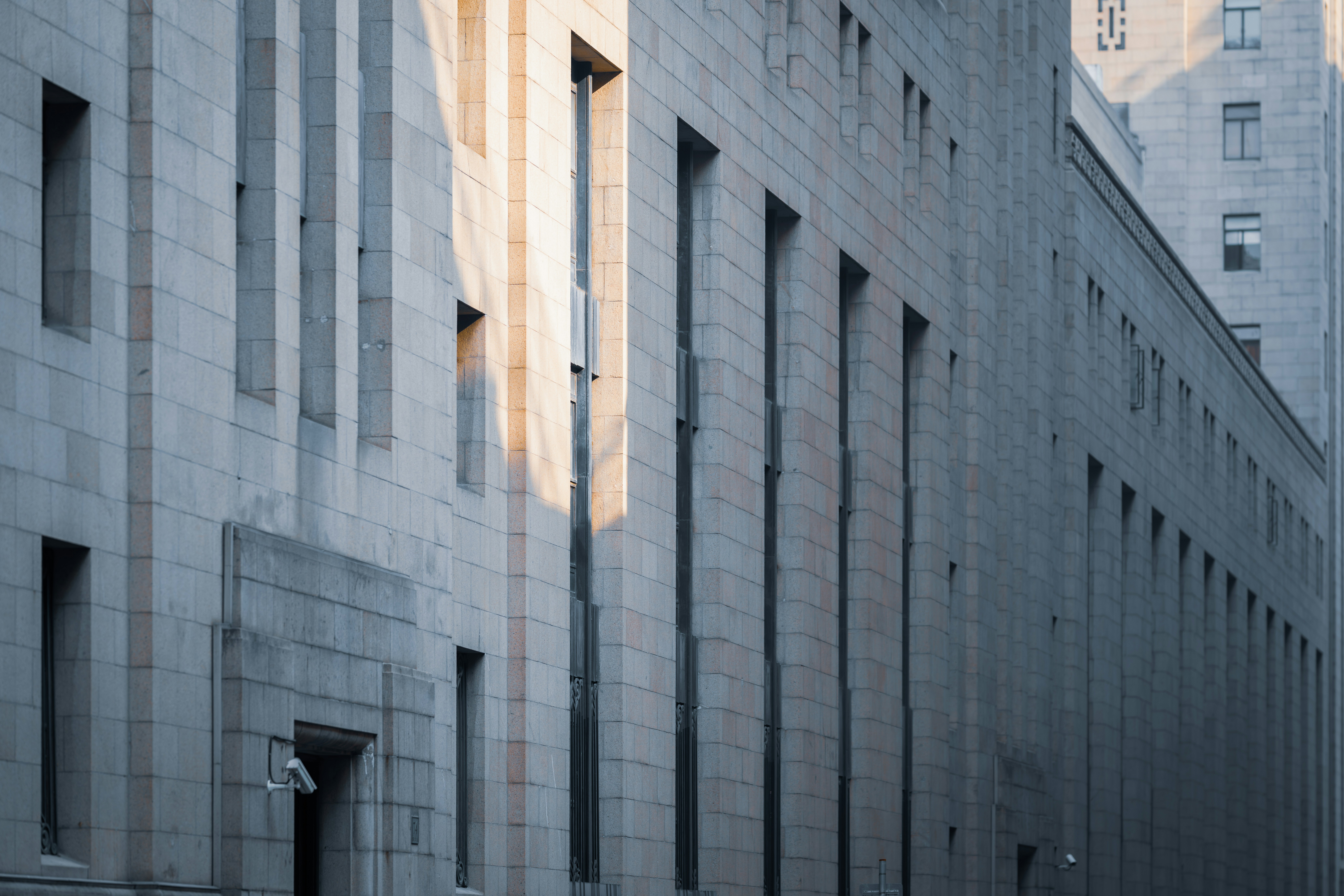 Sunlit Seam on a Blue-Tinted Stone Facade
