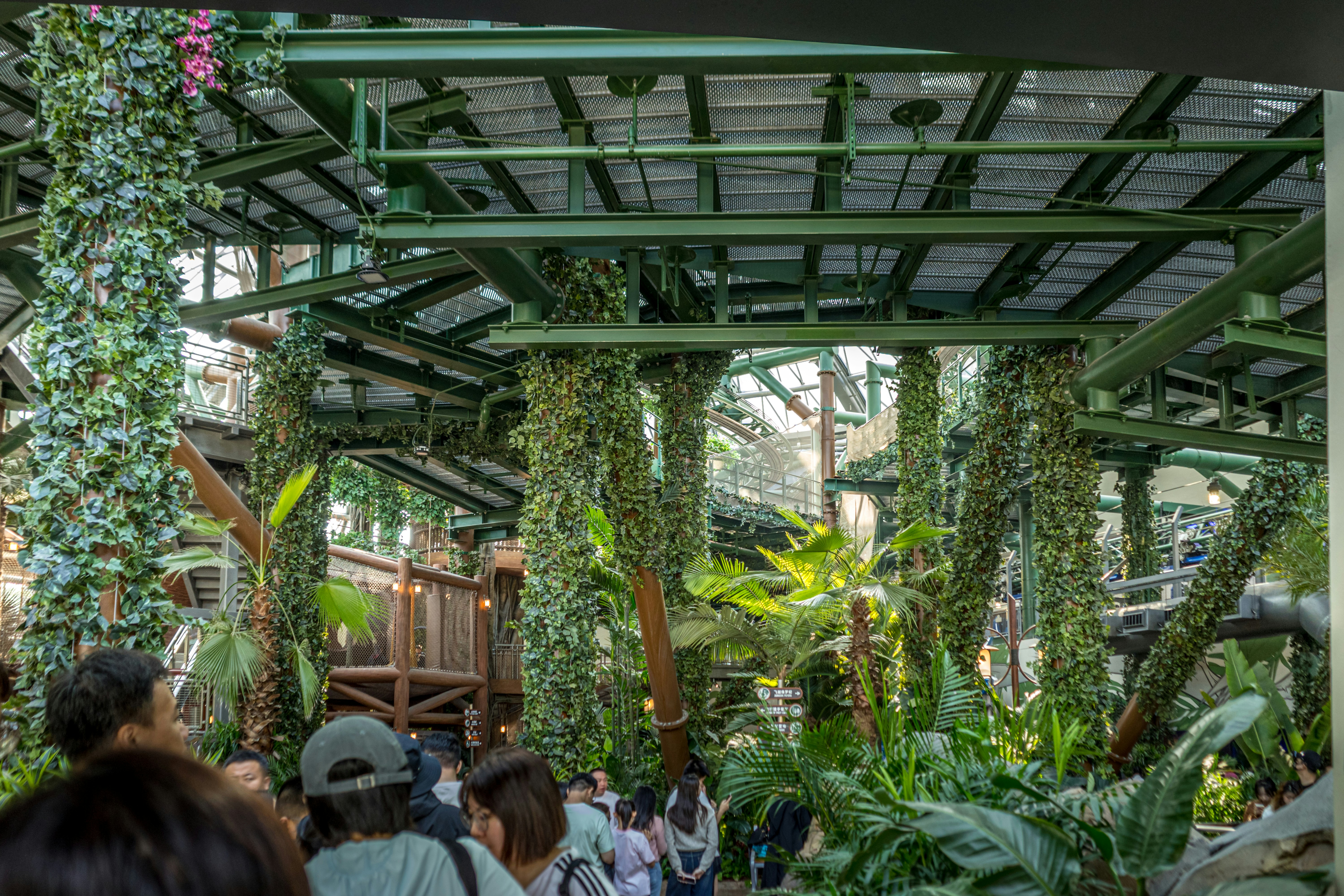 Verdant Canopy, Living Atrium: Visitors beneath a lush greenhouse lattice