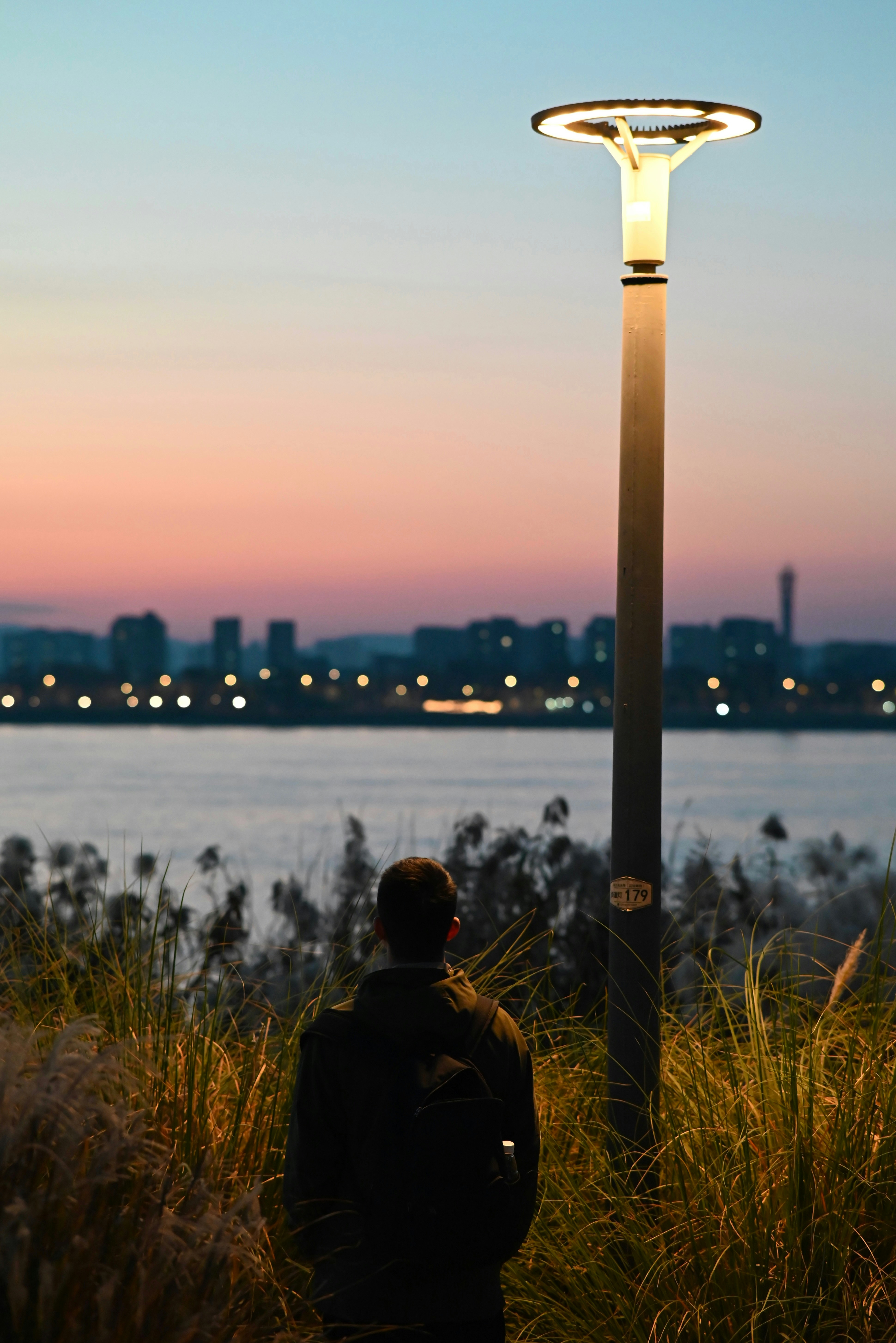 A man sitting on a bench next to a light pole photo – Free 南京市 Image on ...