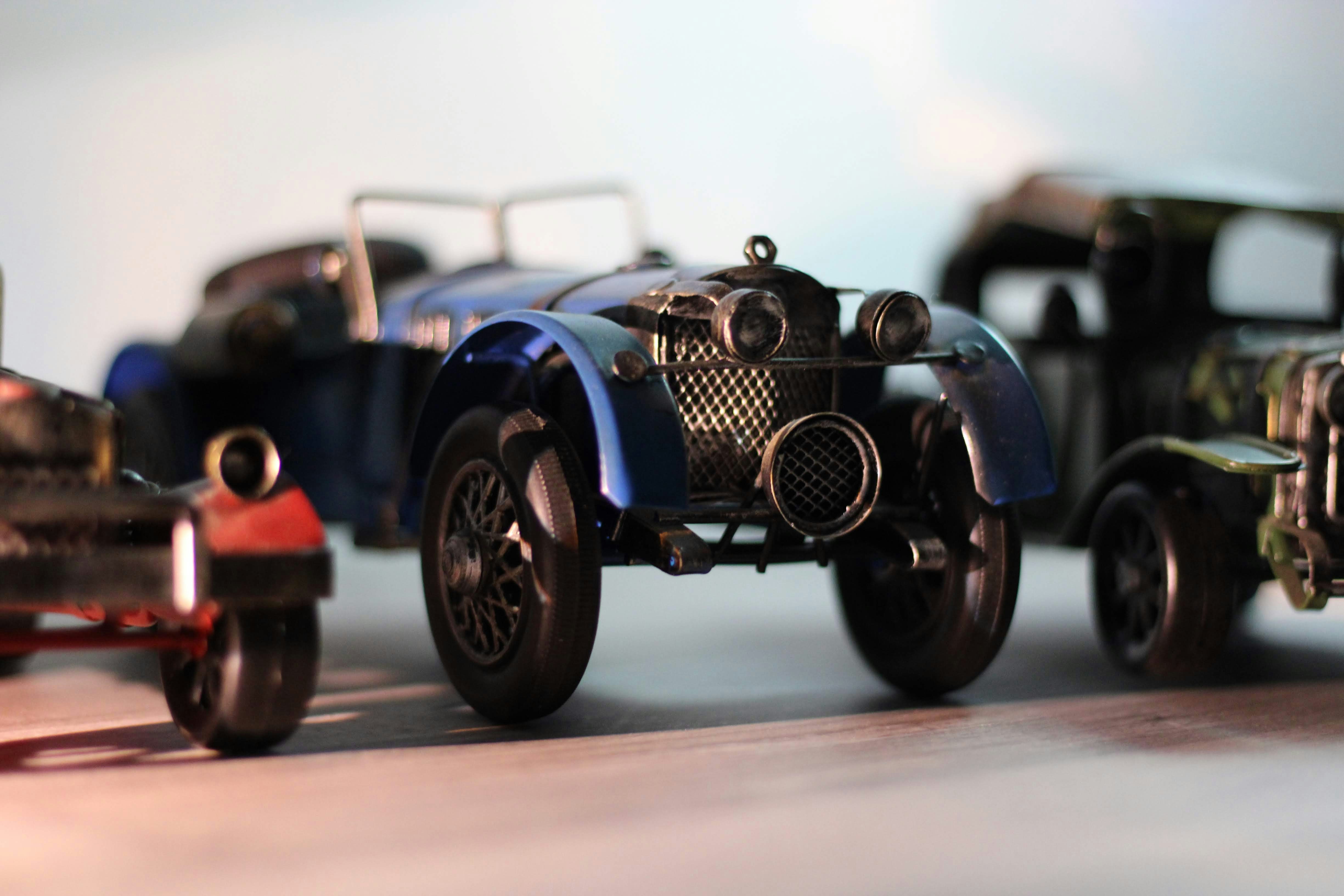 Blue Vintage Racer Among Tiny Metal Companions on a Weathered Table