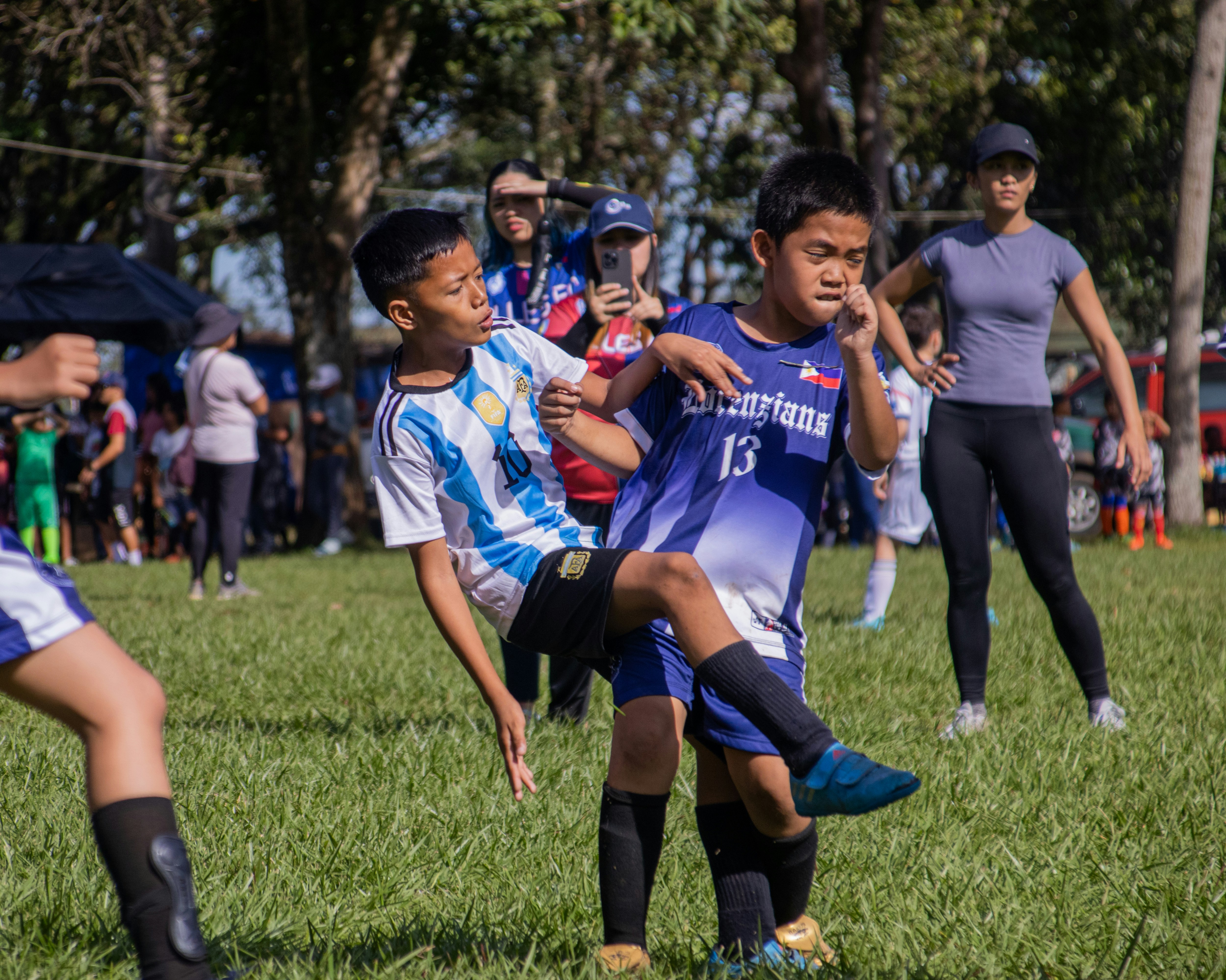 A group of young children playing a game of soccer photo – Free ...