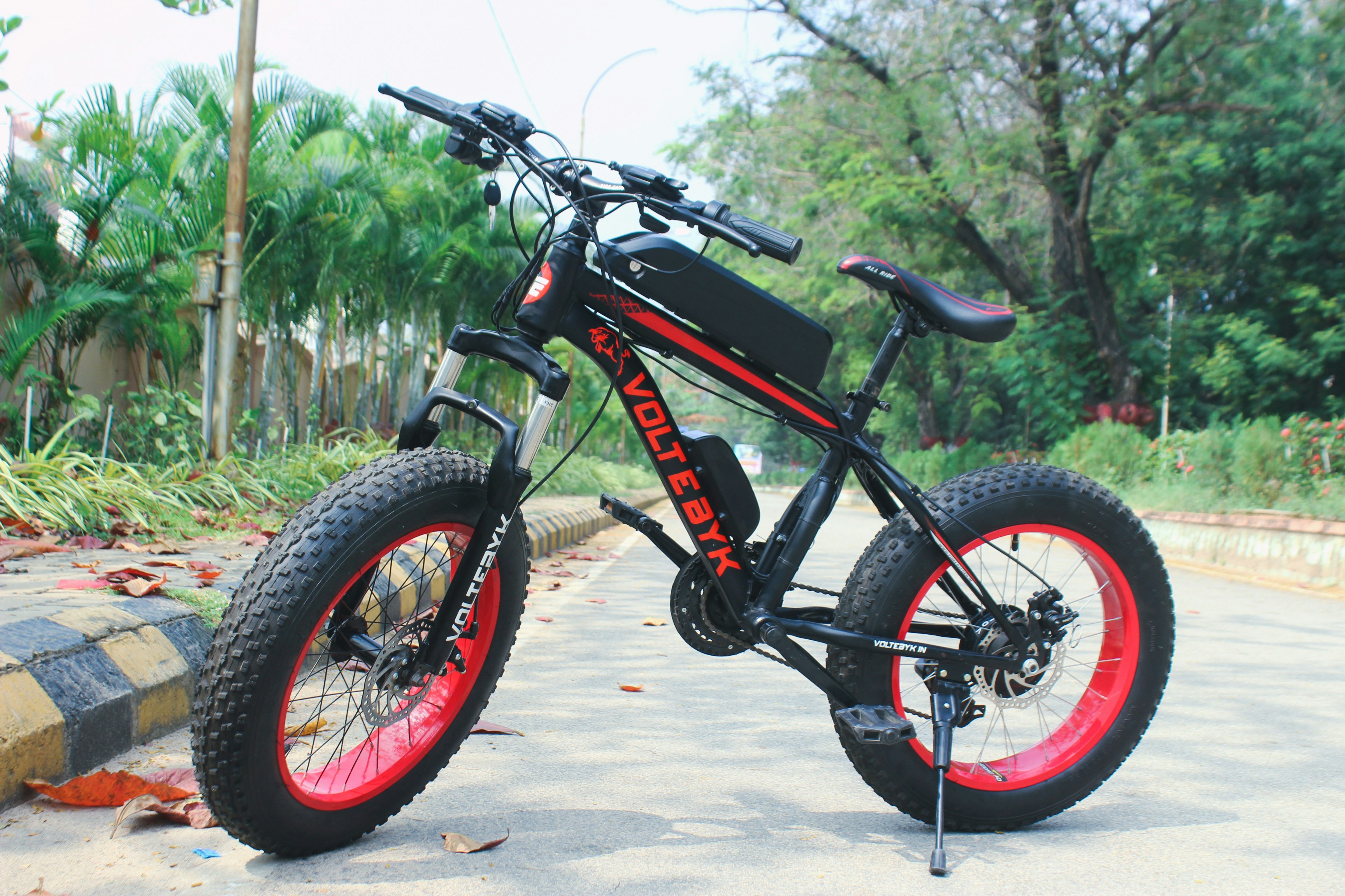 A black and red bike parked on the side of a road photo – Free Bicycle ...