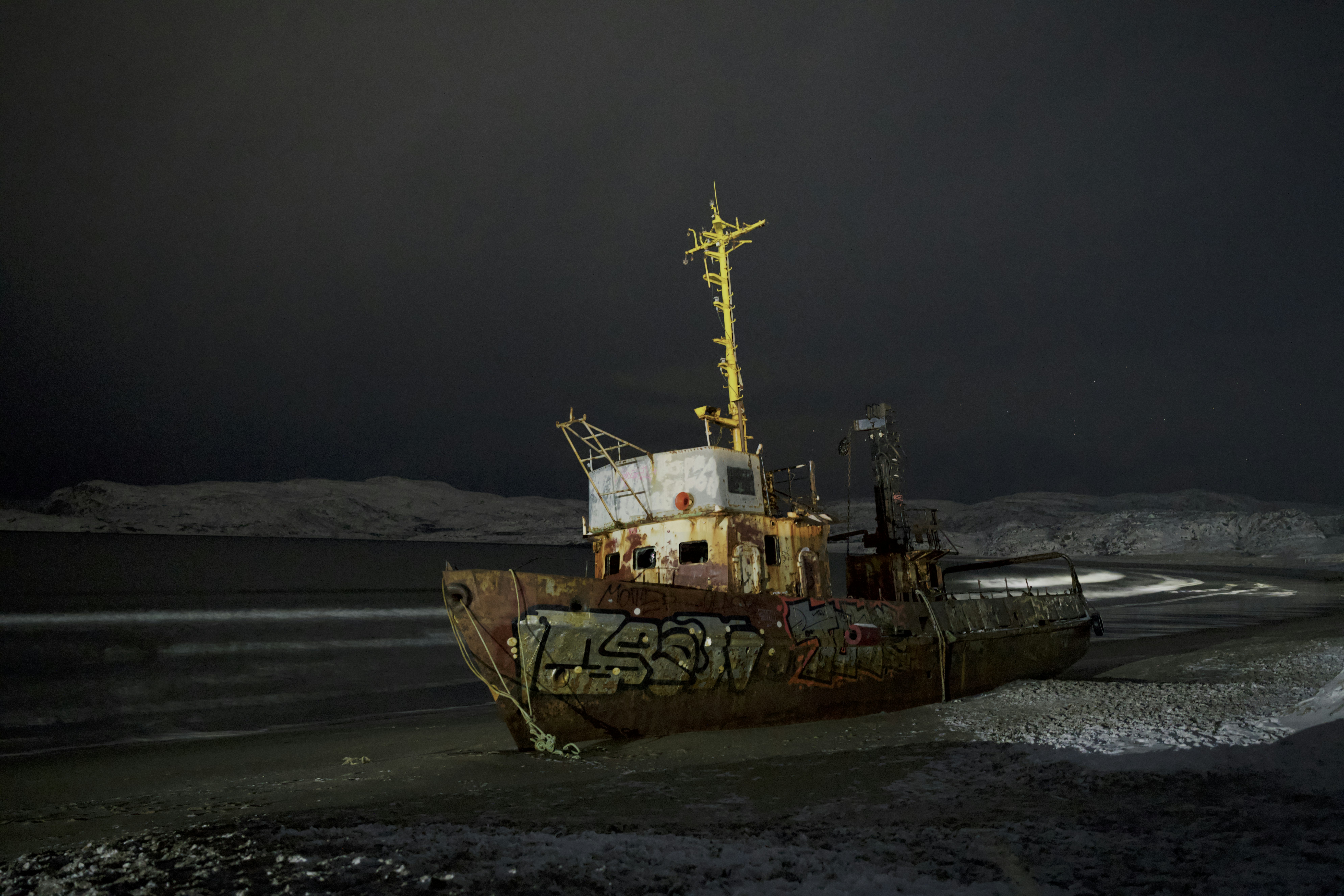 Moonlit Wreck: A rusted tug on a snow-dusted shoreline