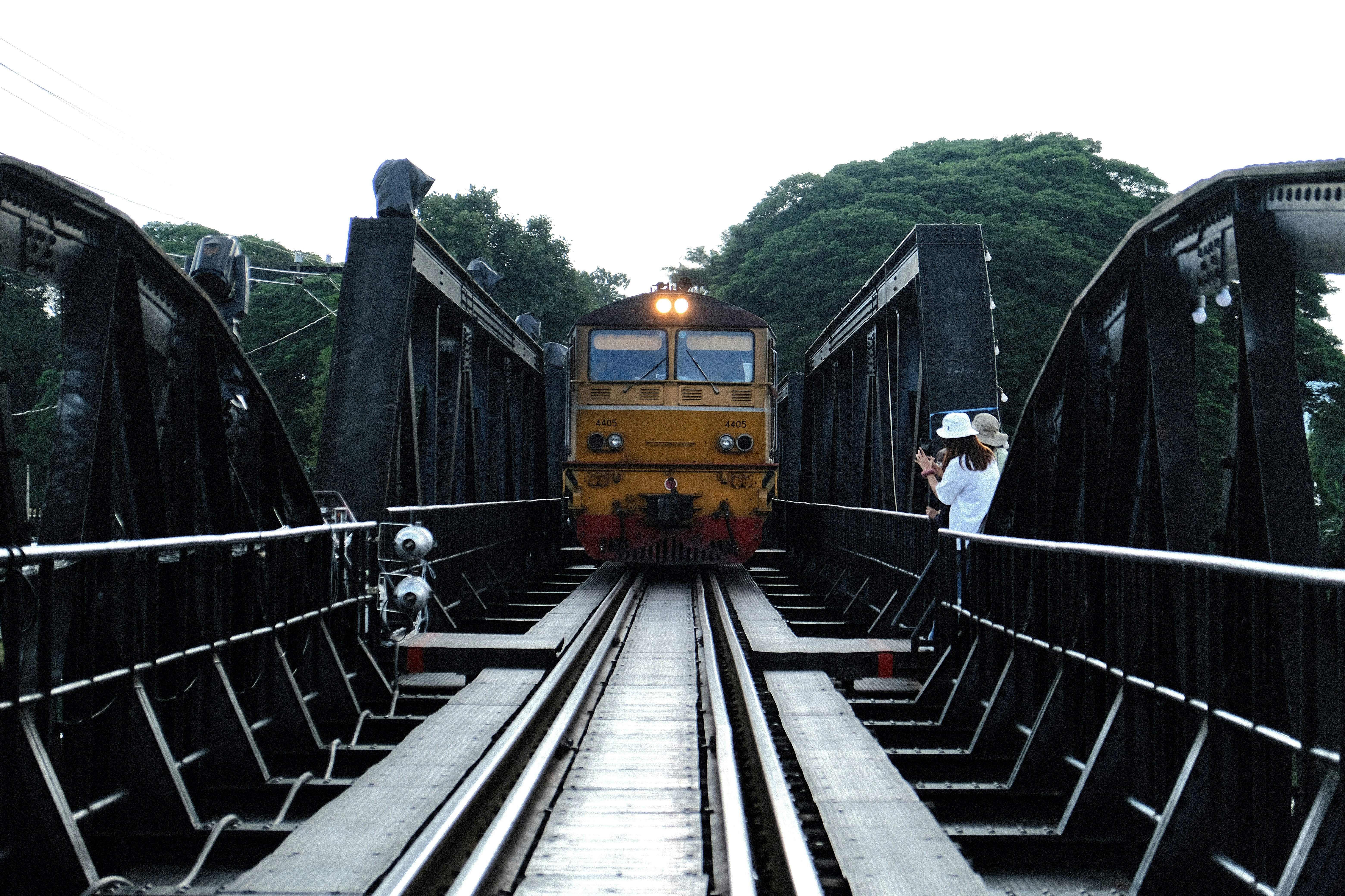 Convergence on Steel: Yellow Locomotive on a Narrow Bridge