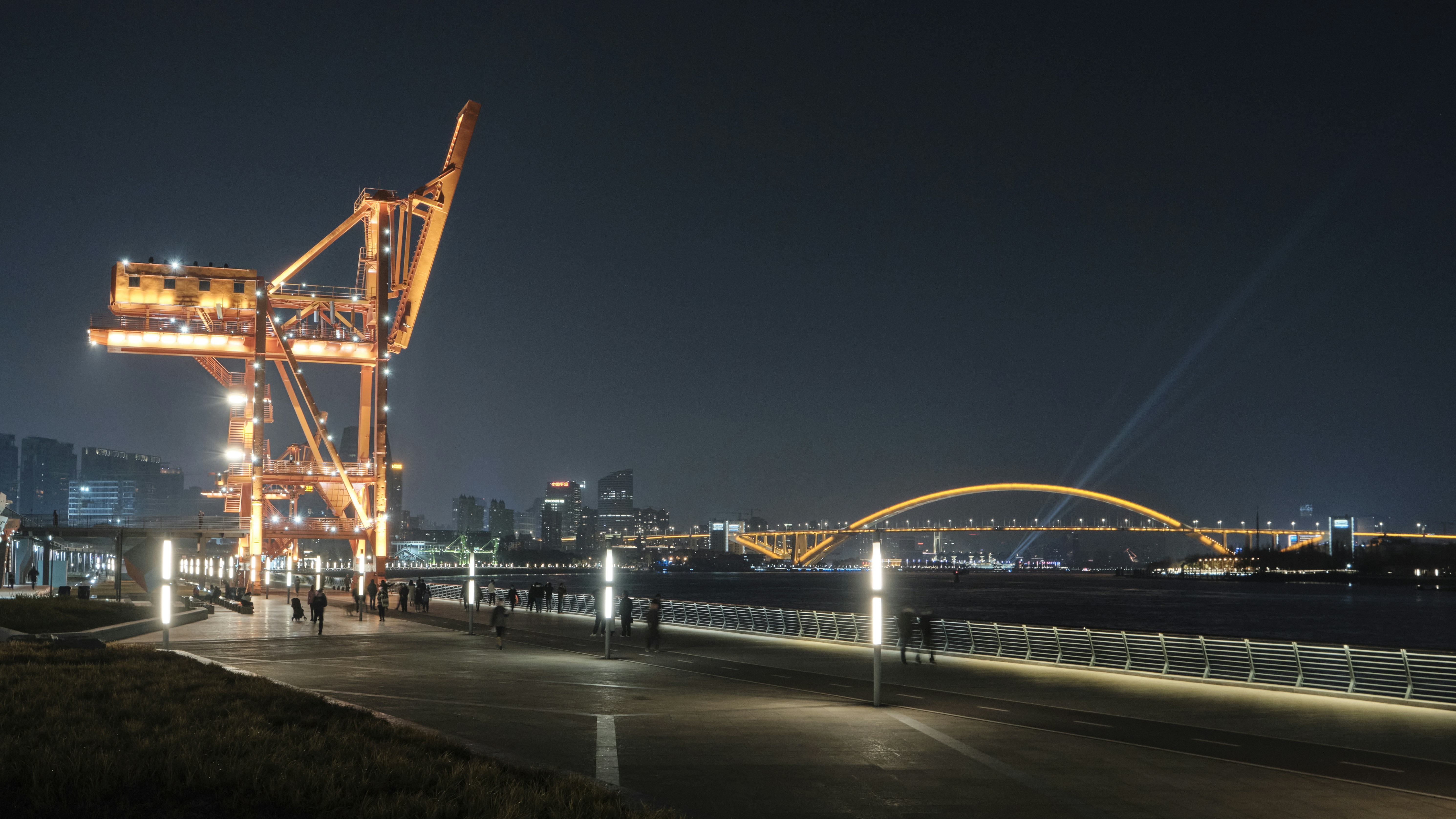 Night Harbor: Machinery and City Lights Align Along the Pier
