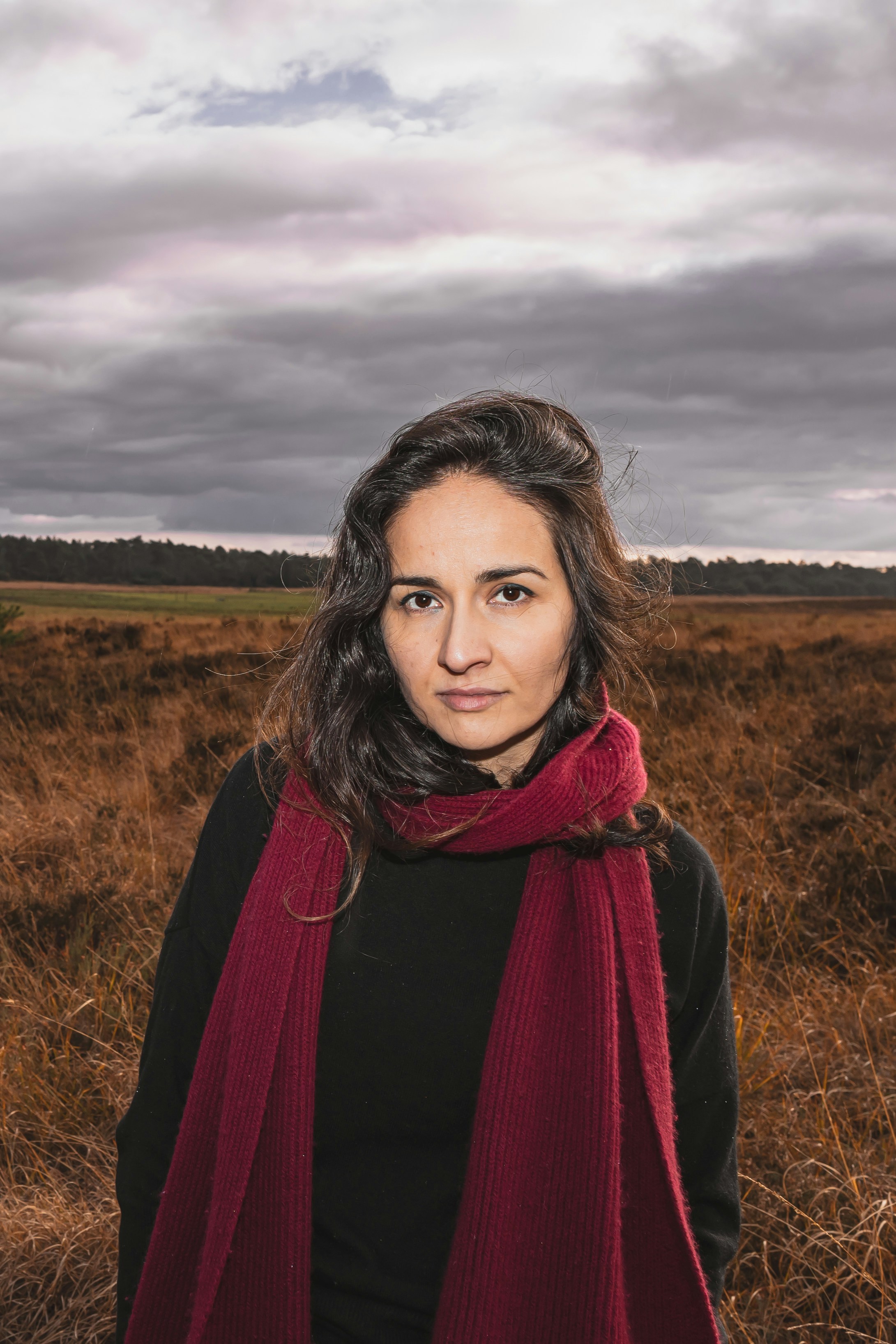 Scarlet Scarf, Quiet Prairie: A Portrait Under Stormy Skies