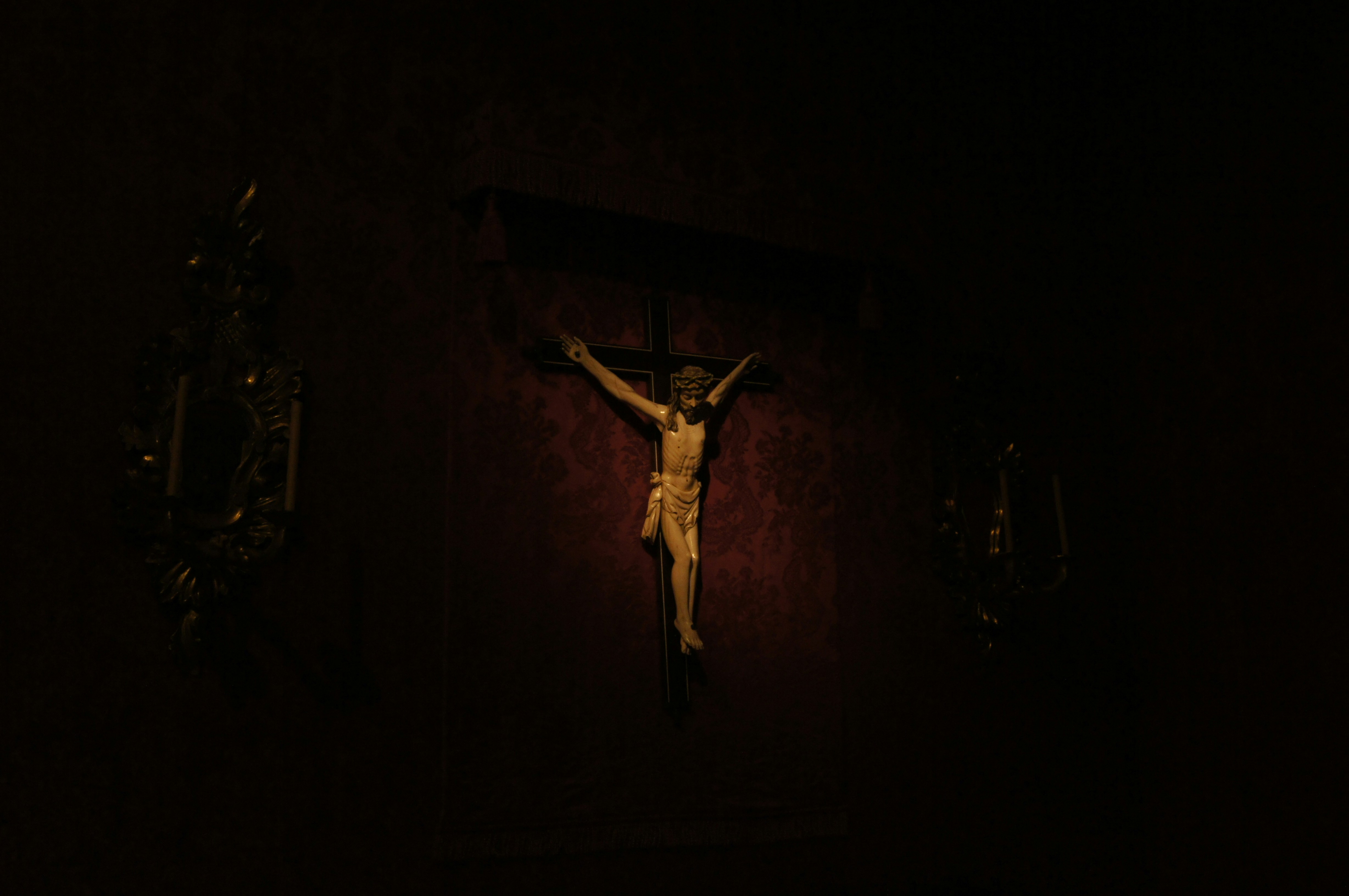 A crucifix in a dark room with a light shining on it photo – Free ...