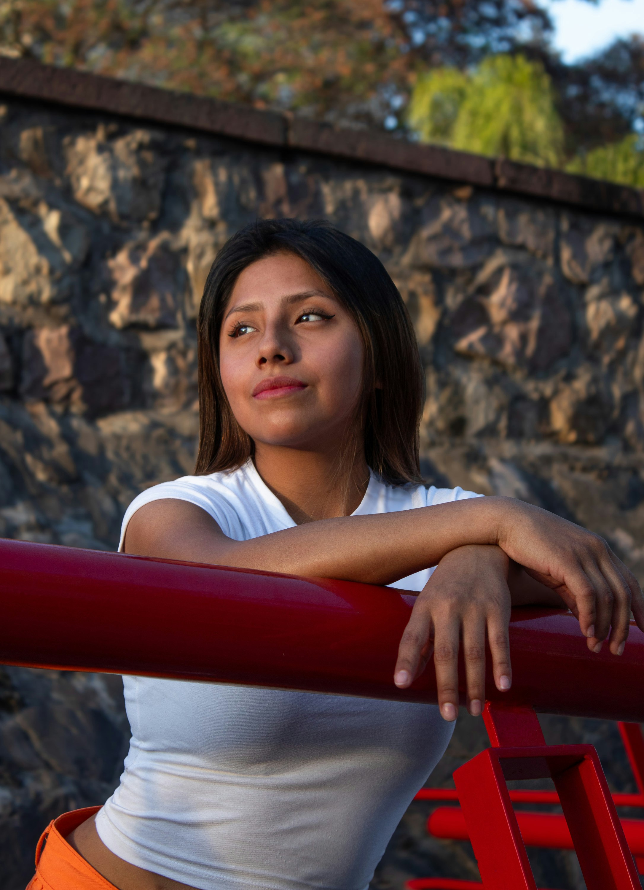 A young woman leaning on a red railing photo – Free Portrait Image on ...