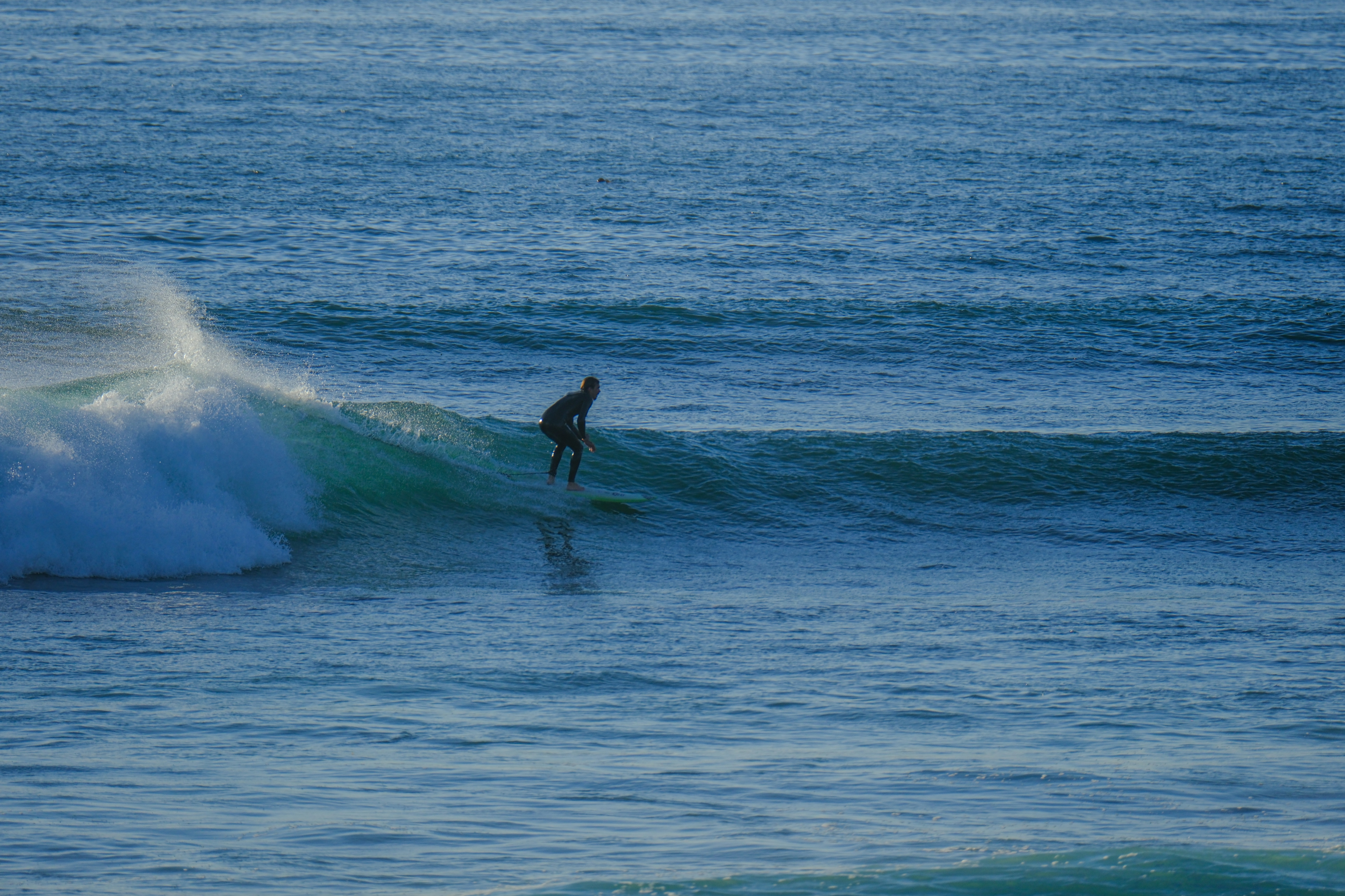 Un homme chevauchant une vague sur une planche de surf photo – Photo ...