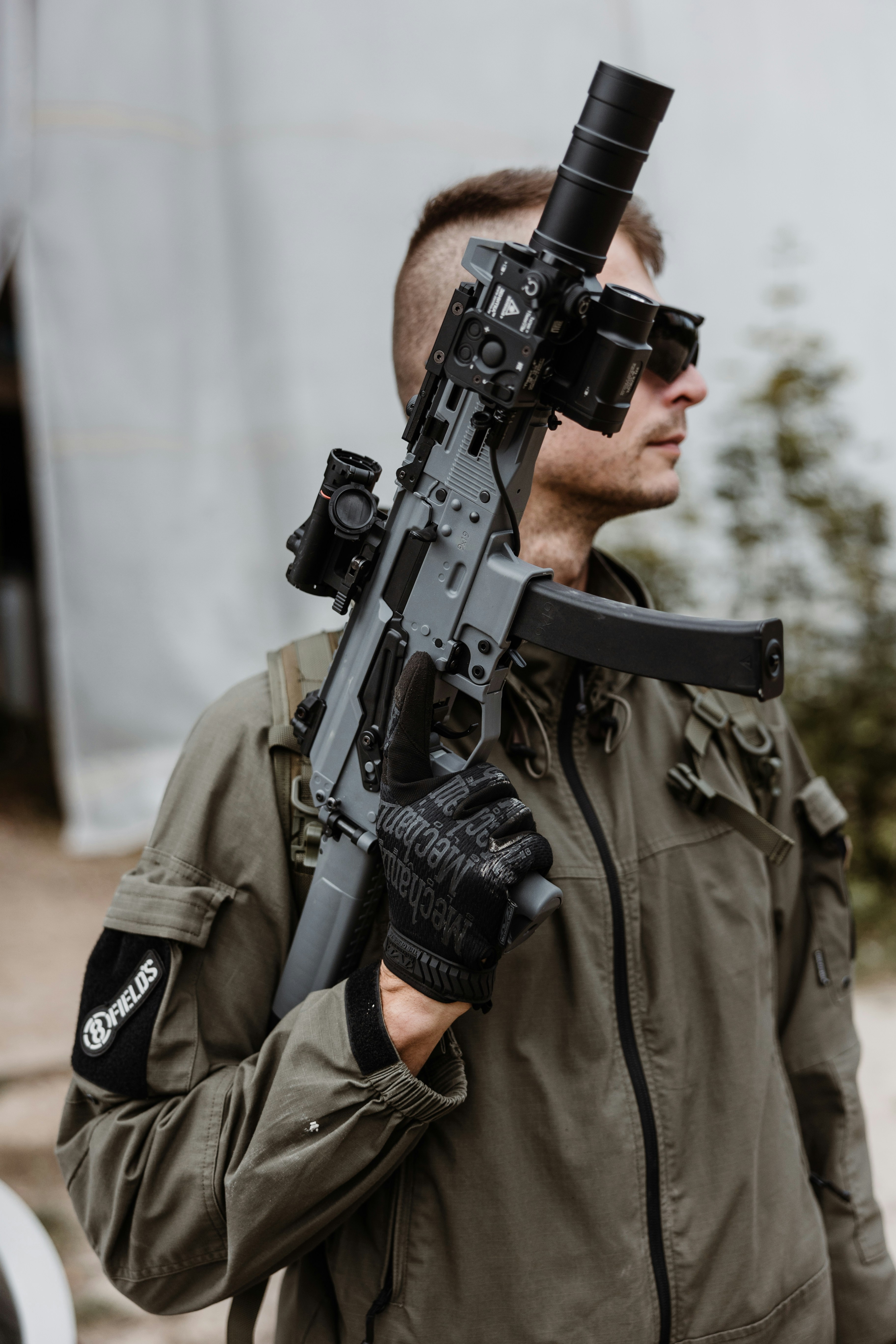 A man holding a machine gun in his hand photo – Free Tactical gear ...