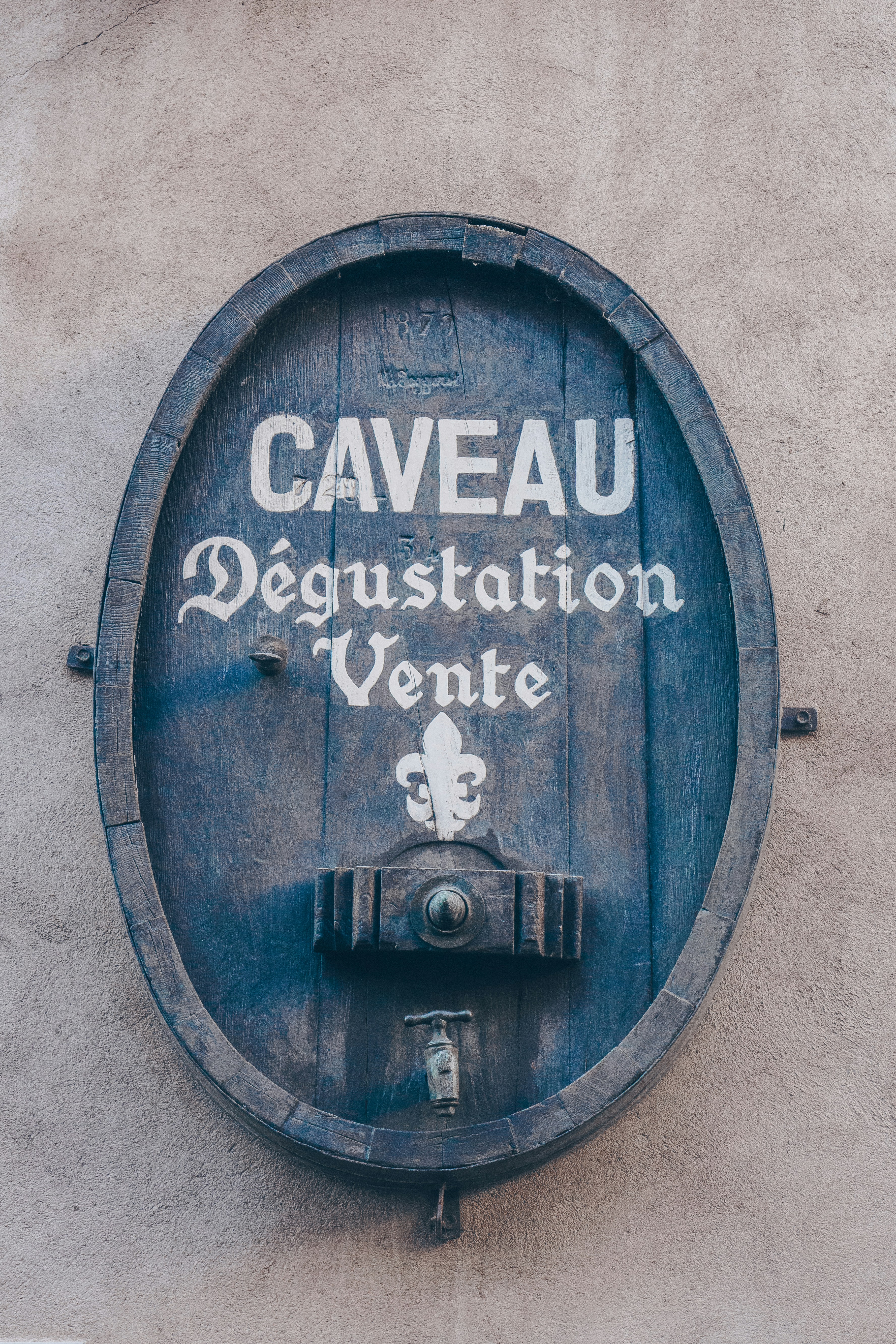 Caveau Dégustation Vente: Weathered Blue Barrel Door on a Rustic Wall