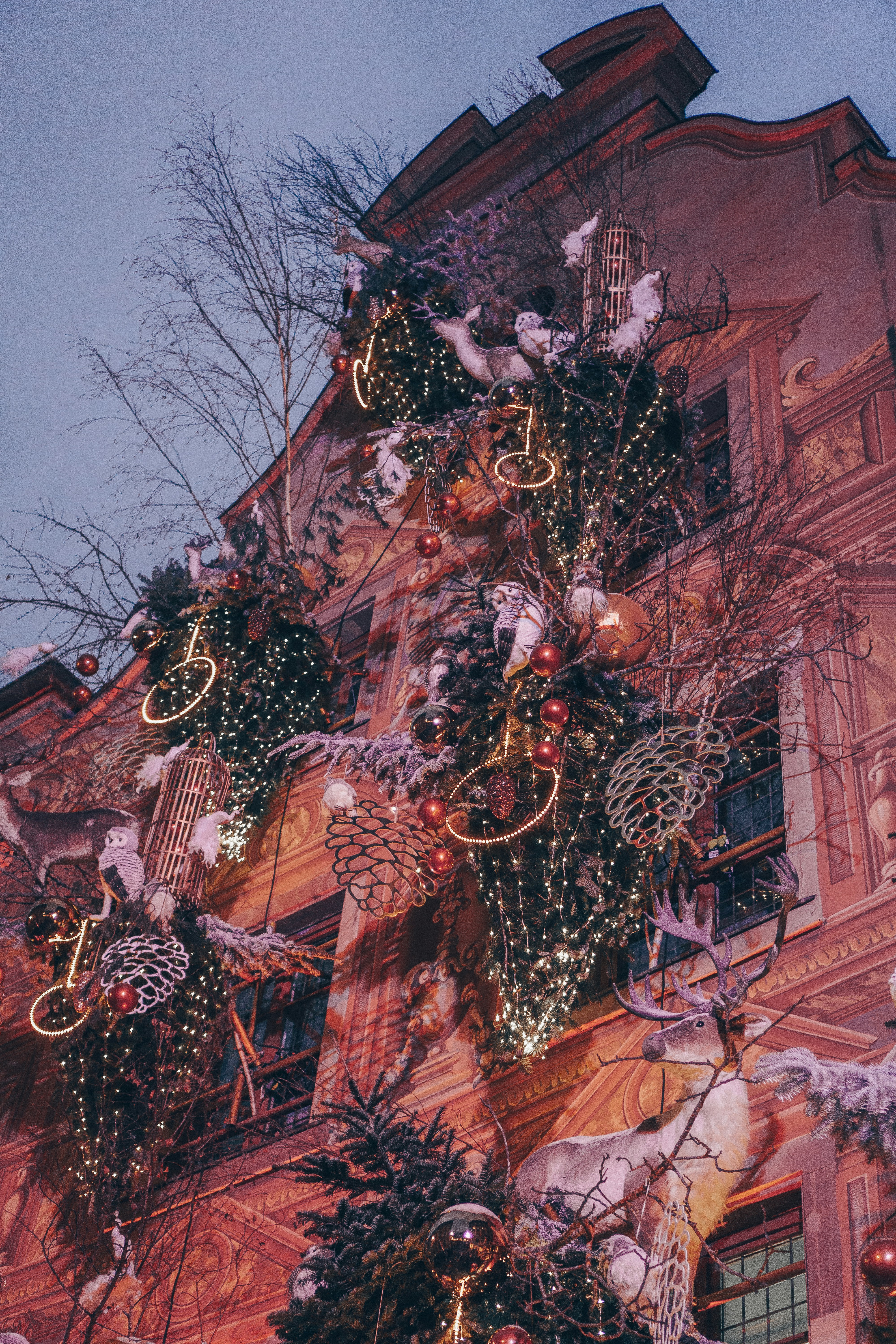 Festive Facade: Illuminated Ornaments Draped Over a Historic Building