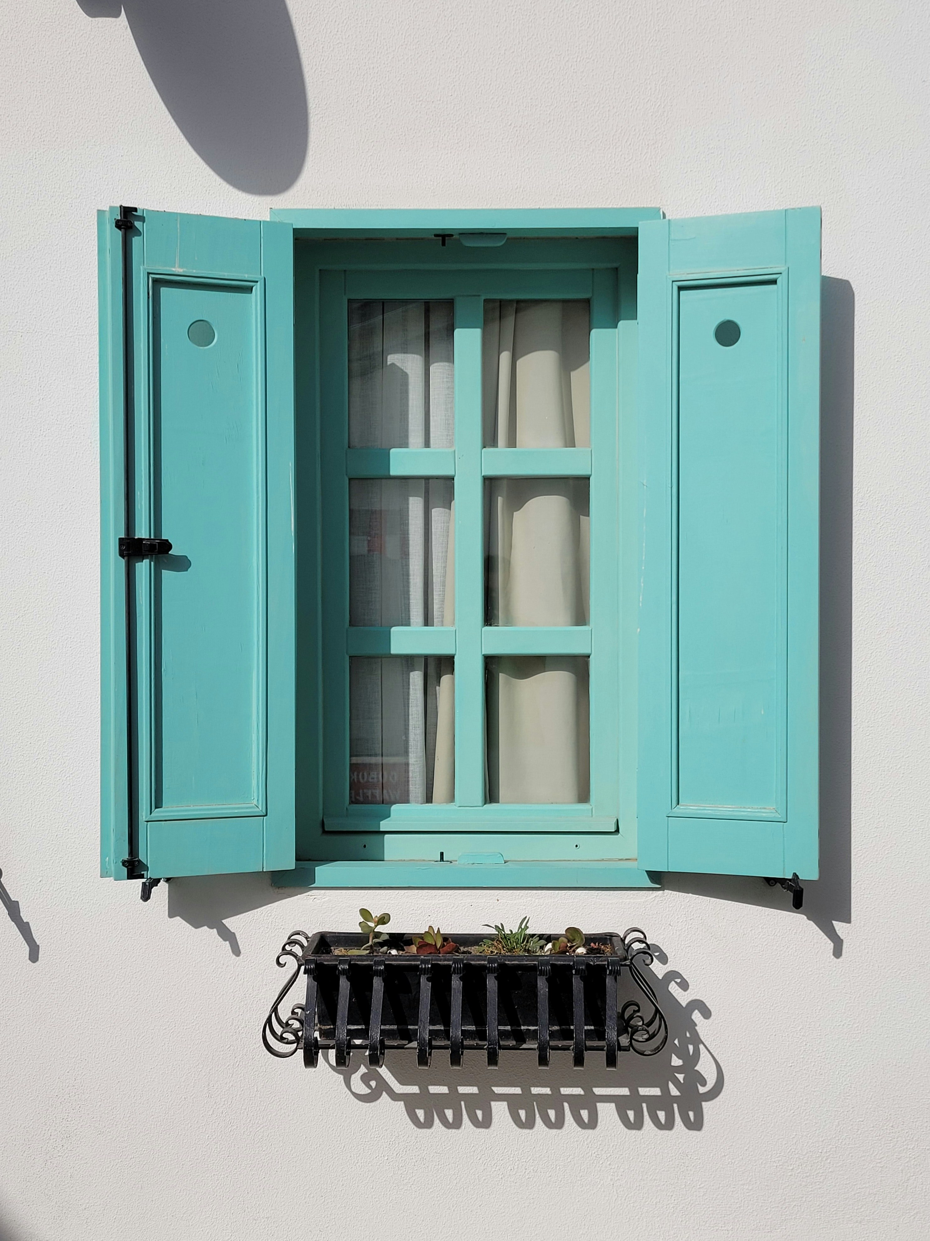 Turquoise Shutters on White Facade: A Quiet Mediterranean Moment