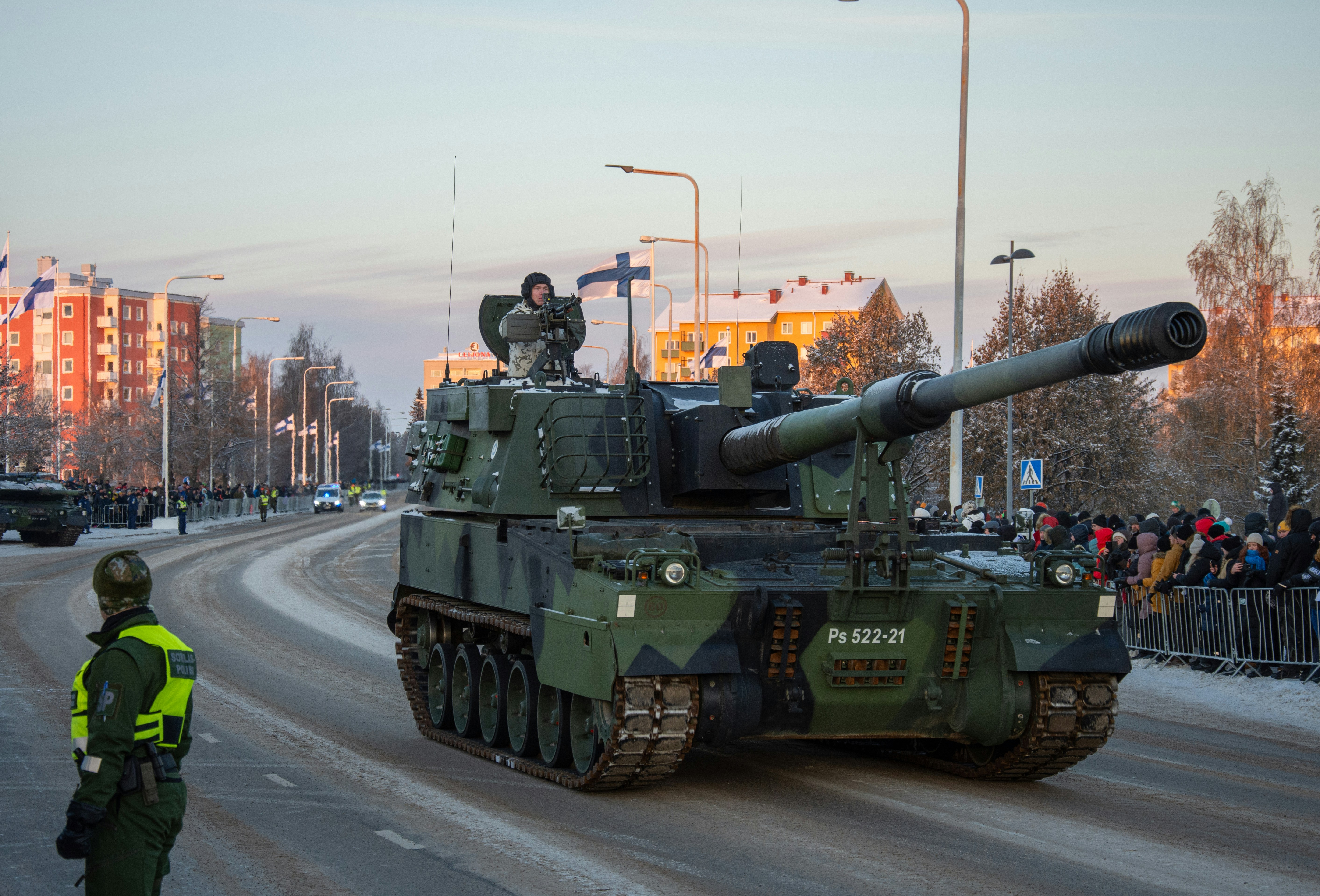 A tank driving down a street next to a crowd of people photo – Free ...