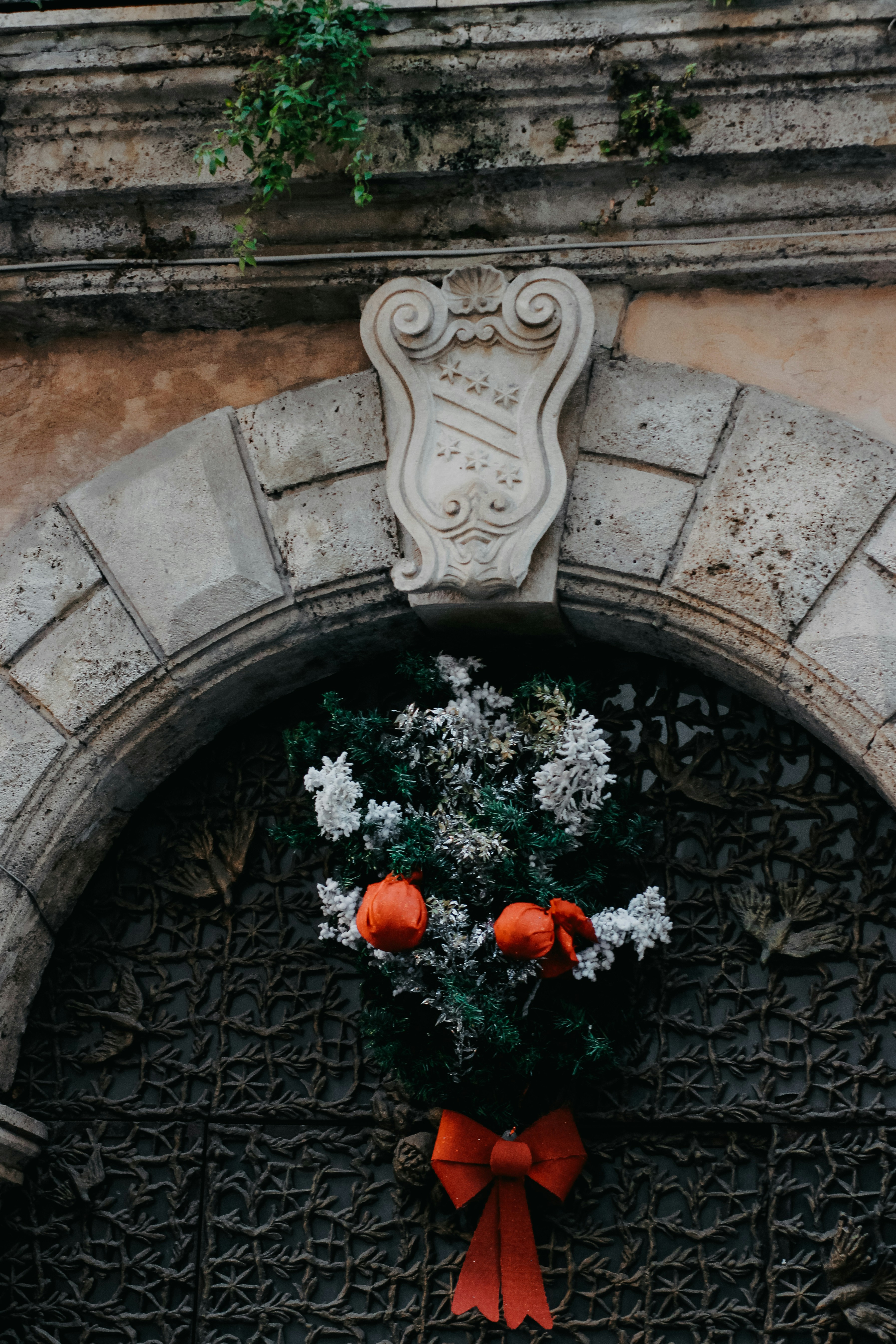 Heraldic Arch Gardener: A Red Bow Draped Between Stone and Florals