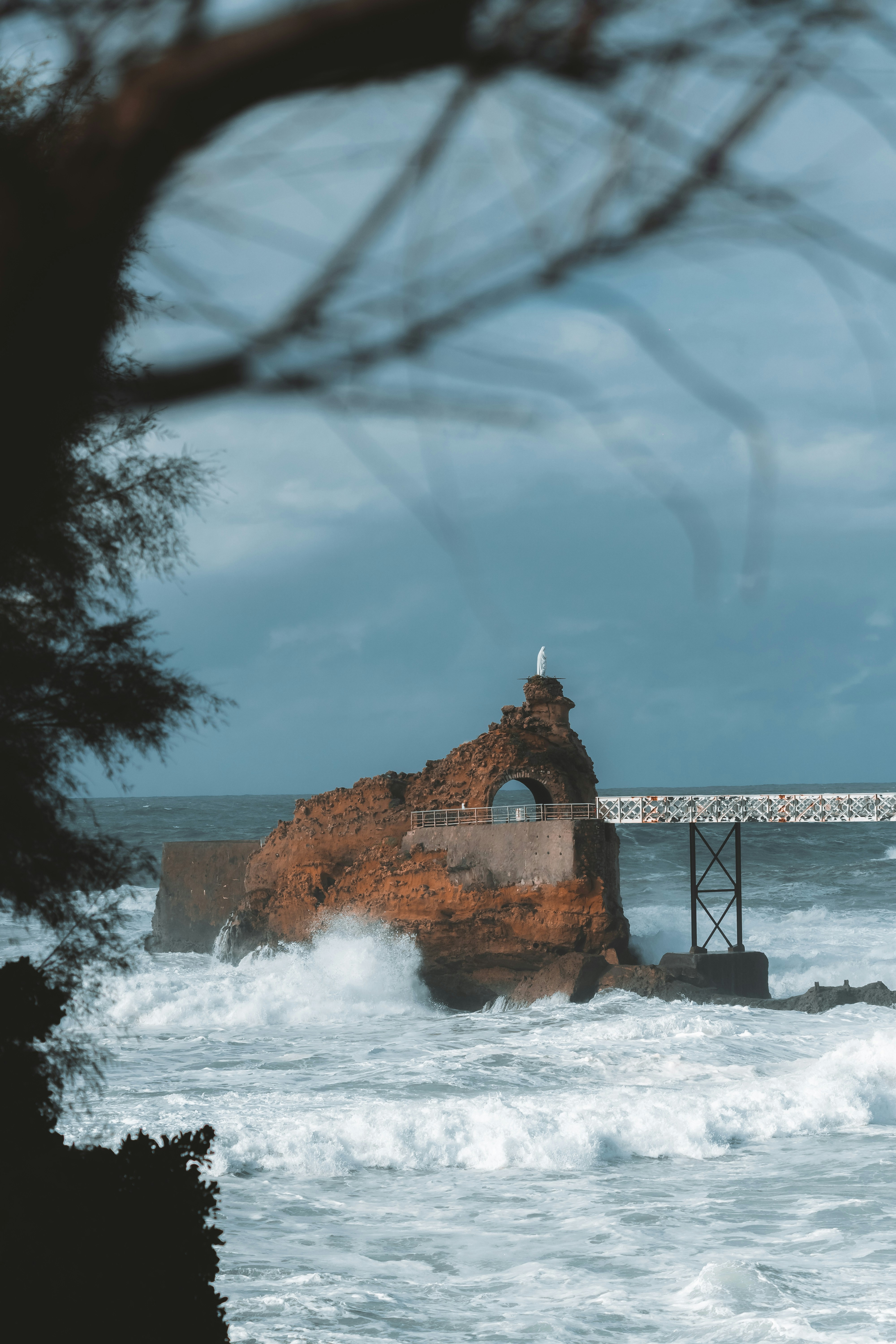 Rock Arch Reach: A Weathered Pier Extends Toward Surging Sea