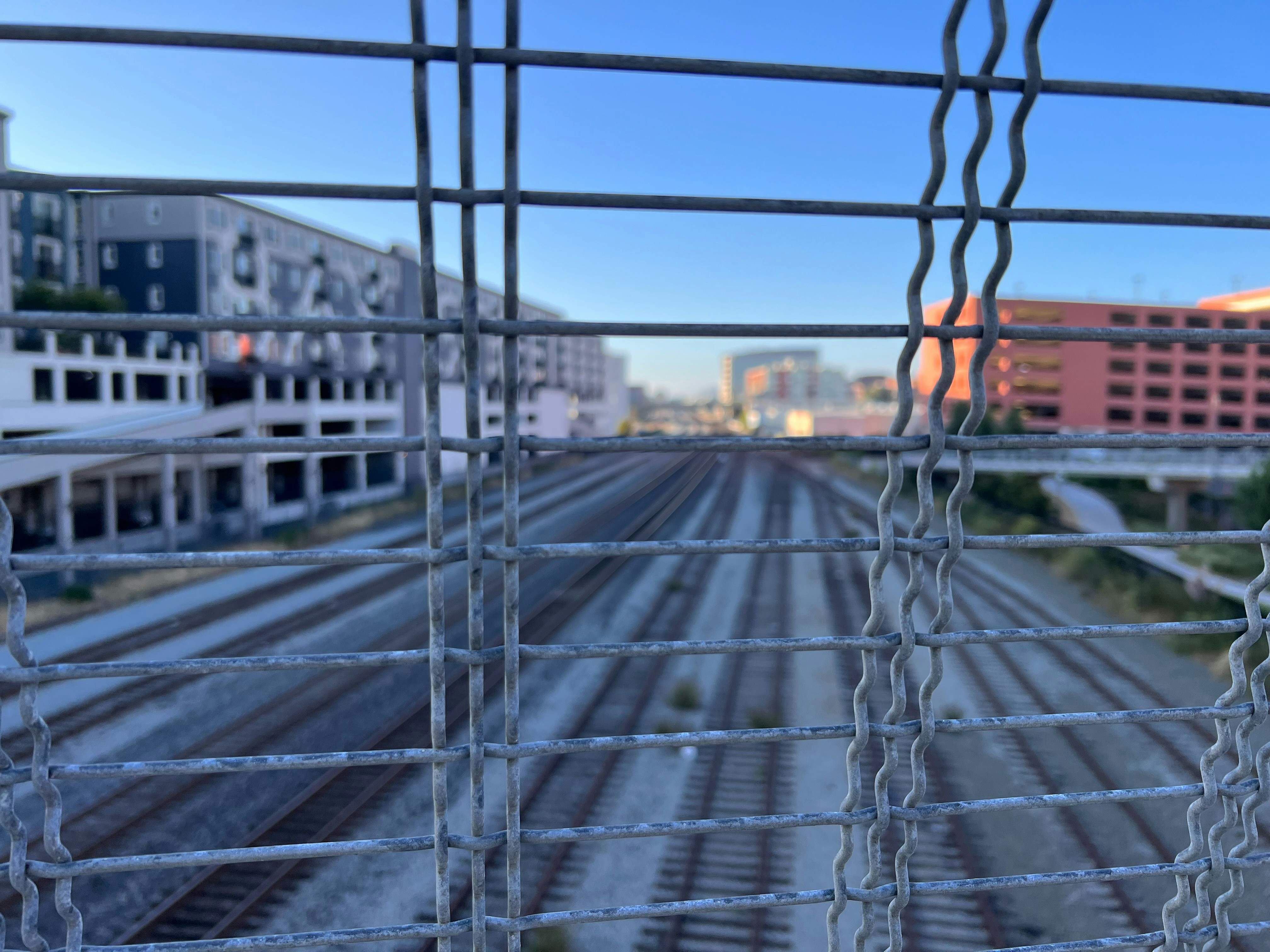 A view of a train track through a wire fence photo – Free City Image on ...