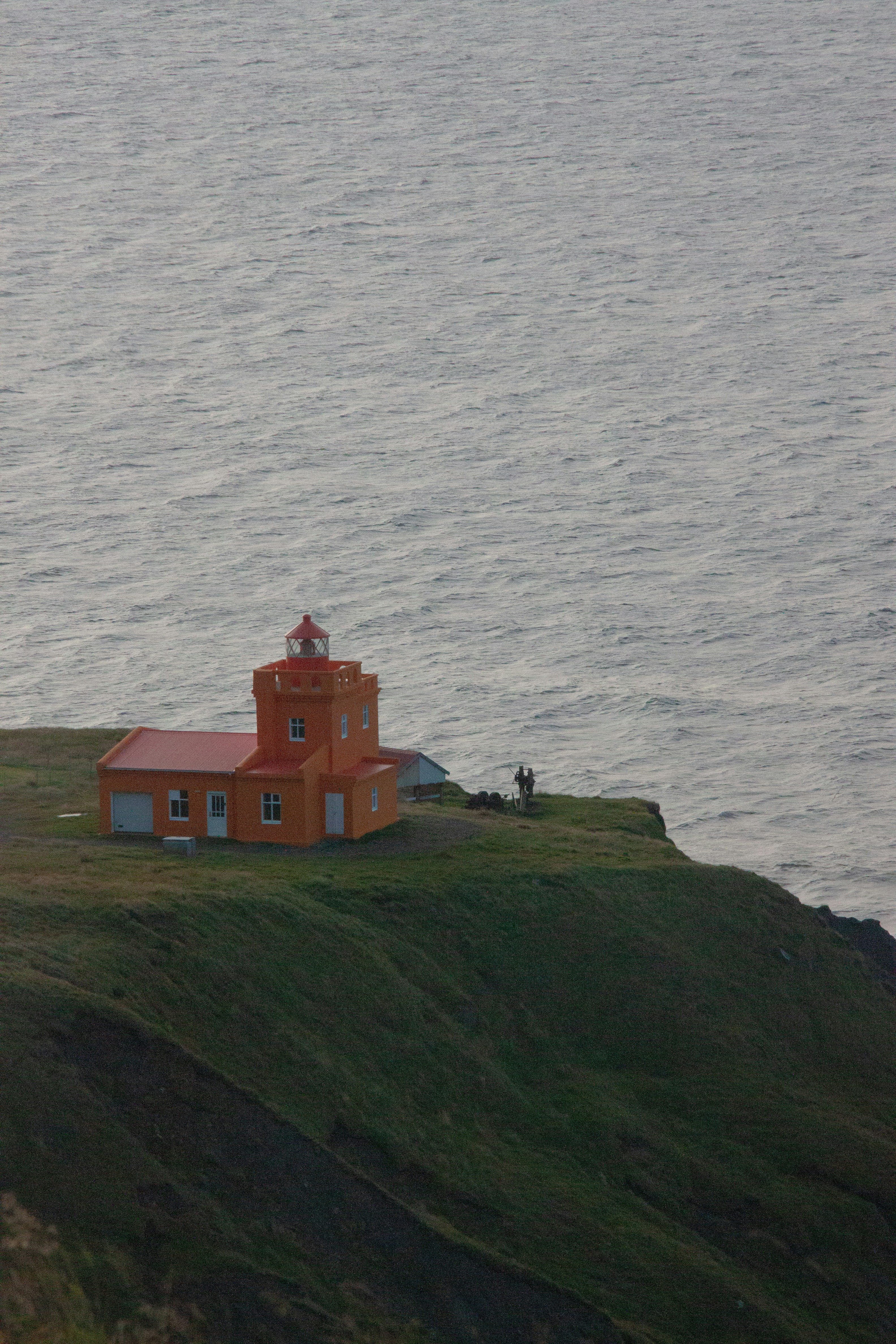Ember Lighthouse on a Cliff: Orange Sentinel Over the Quiet Sea