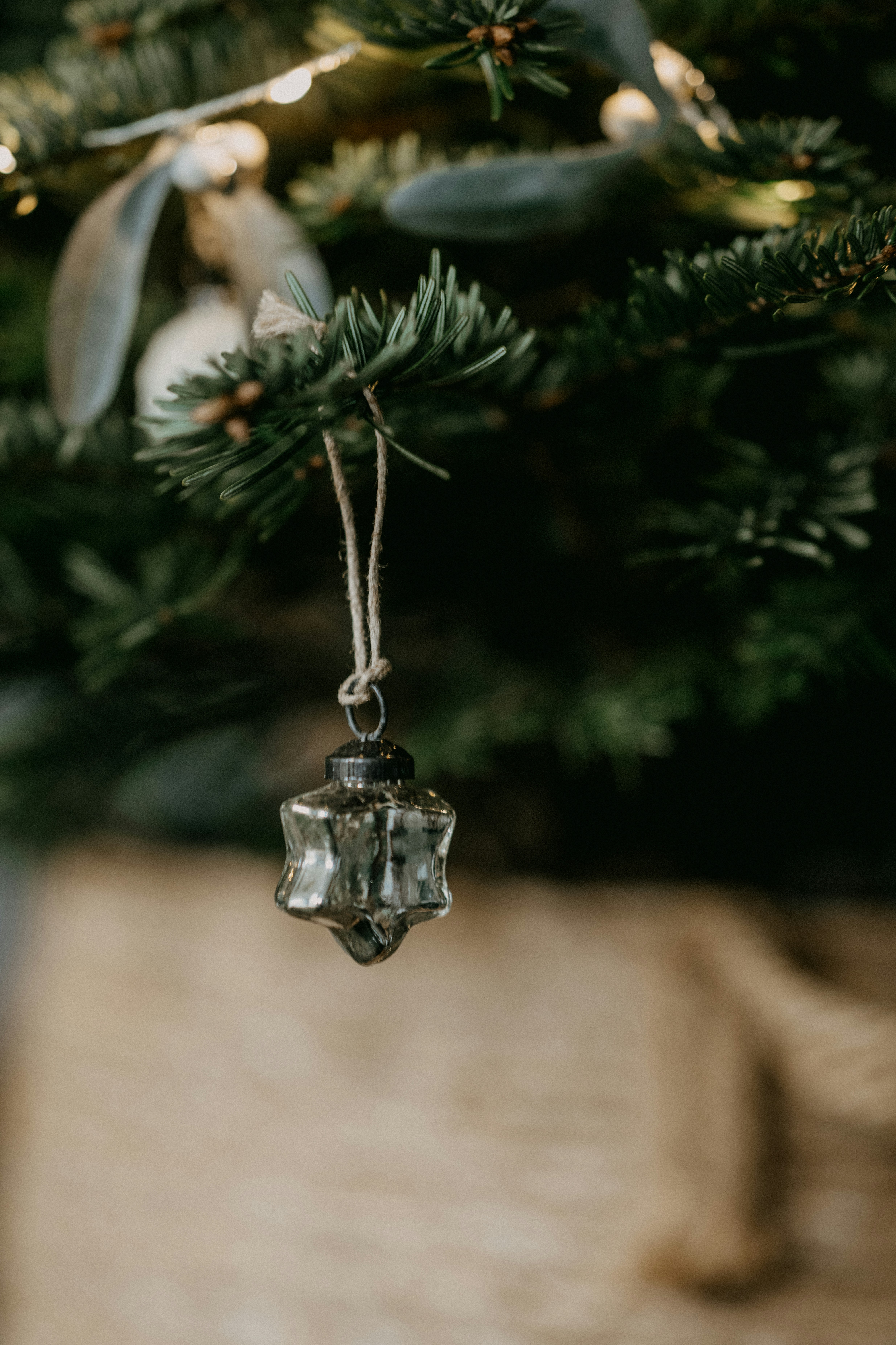 A Tiny Bell Dangles from a Pine, Softly Framed by Holiday Greenery