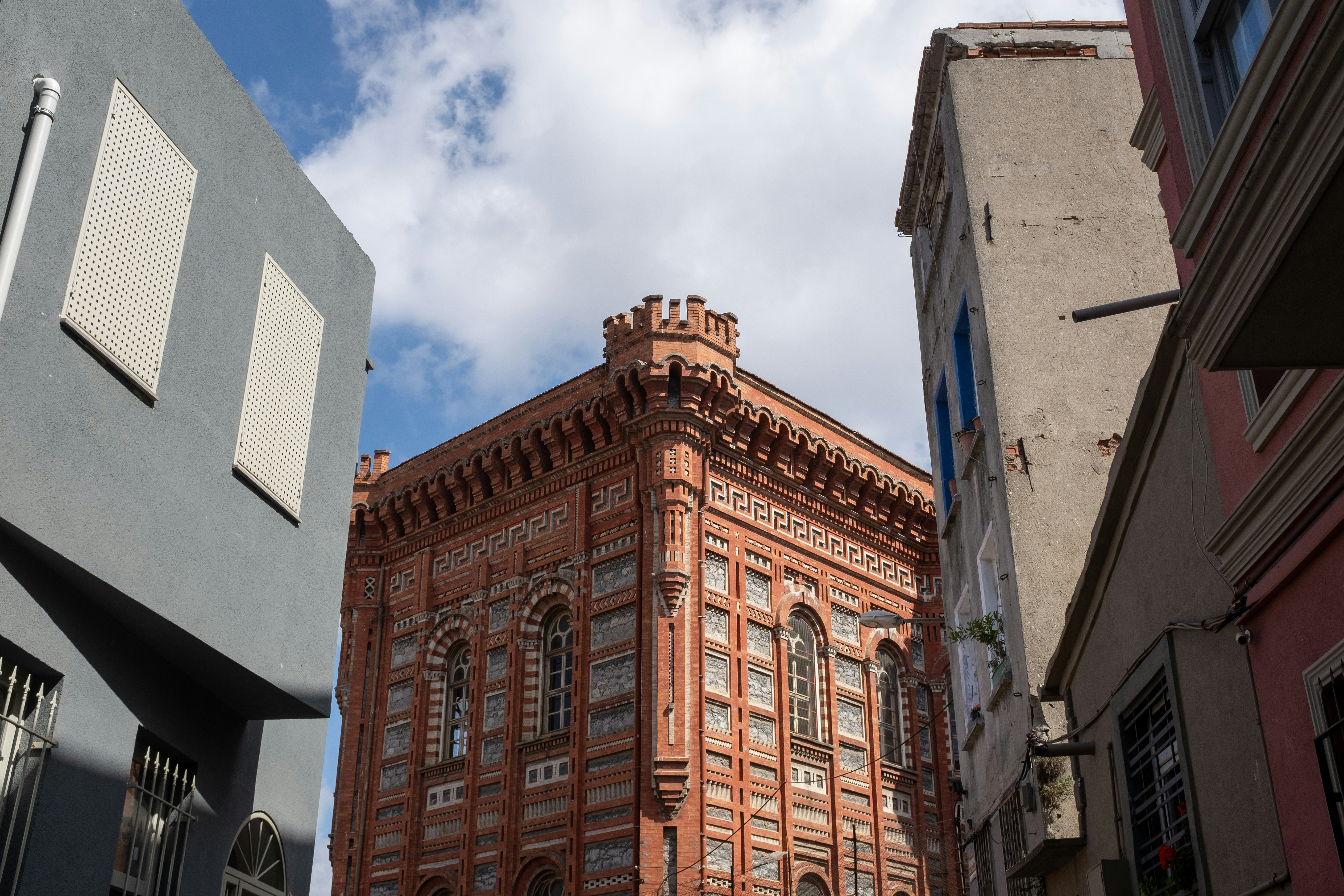 Red Brick Crown: A Narrow Street Scene Between Modern and Historic Facades