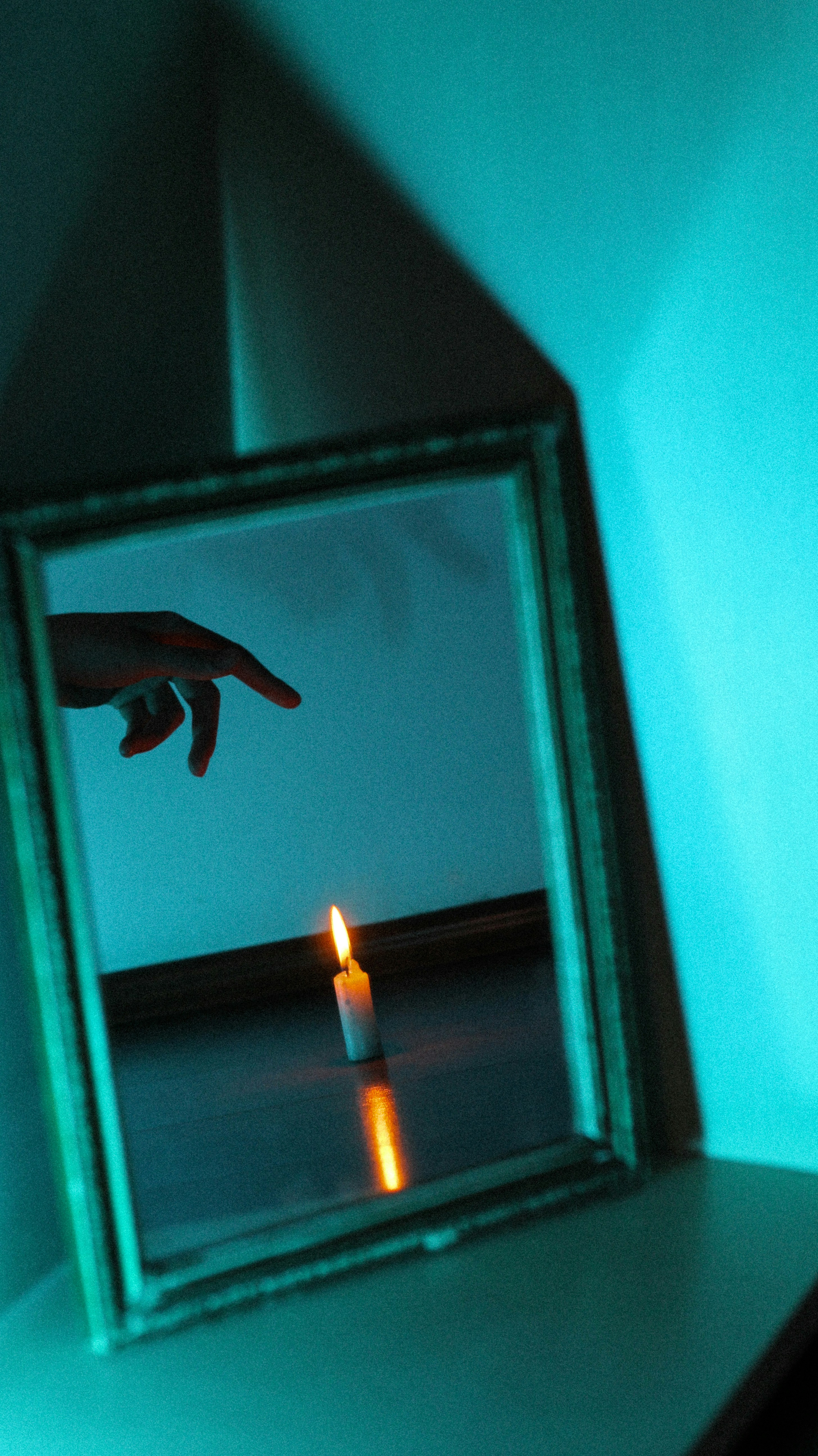 A reflection of a candle in a mirror photo – Free Human Image on Unsplash