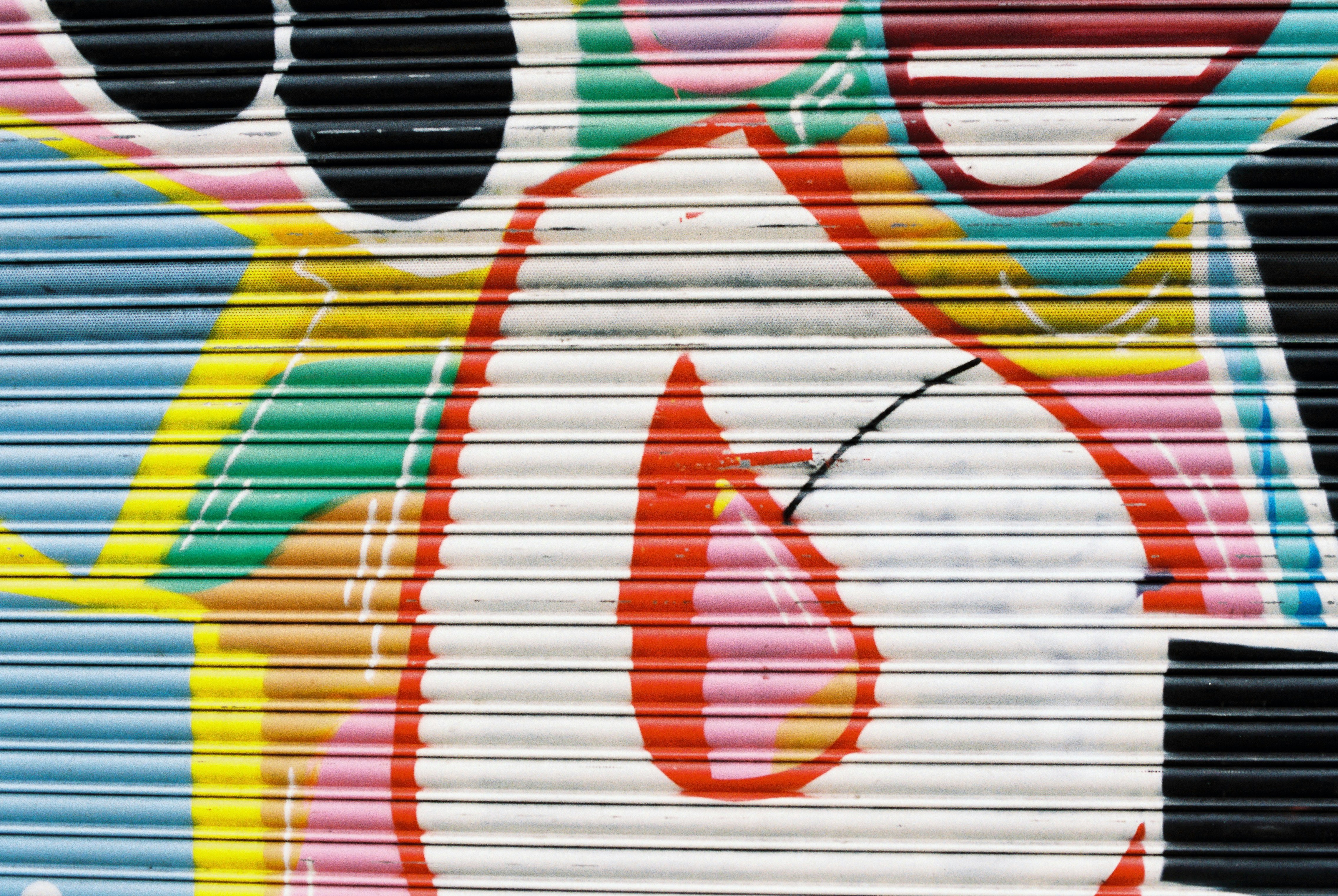 Crimson Teardrop Anchored by a Rainbow Graffiti Shutter