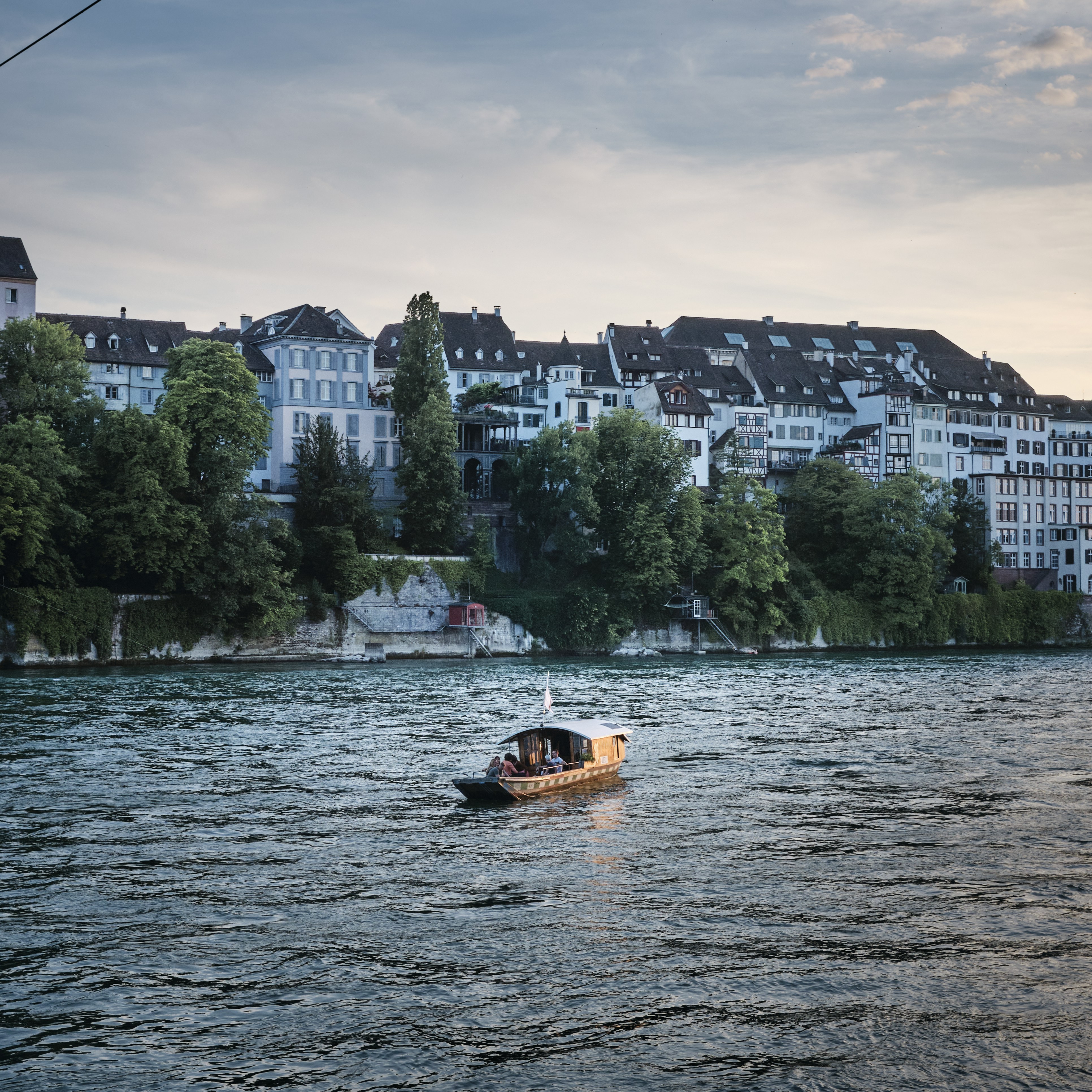 A small boat floating on top of a river next to tall buildings photo ...