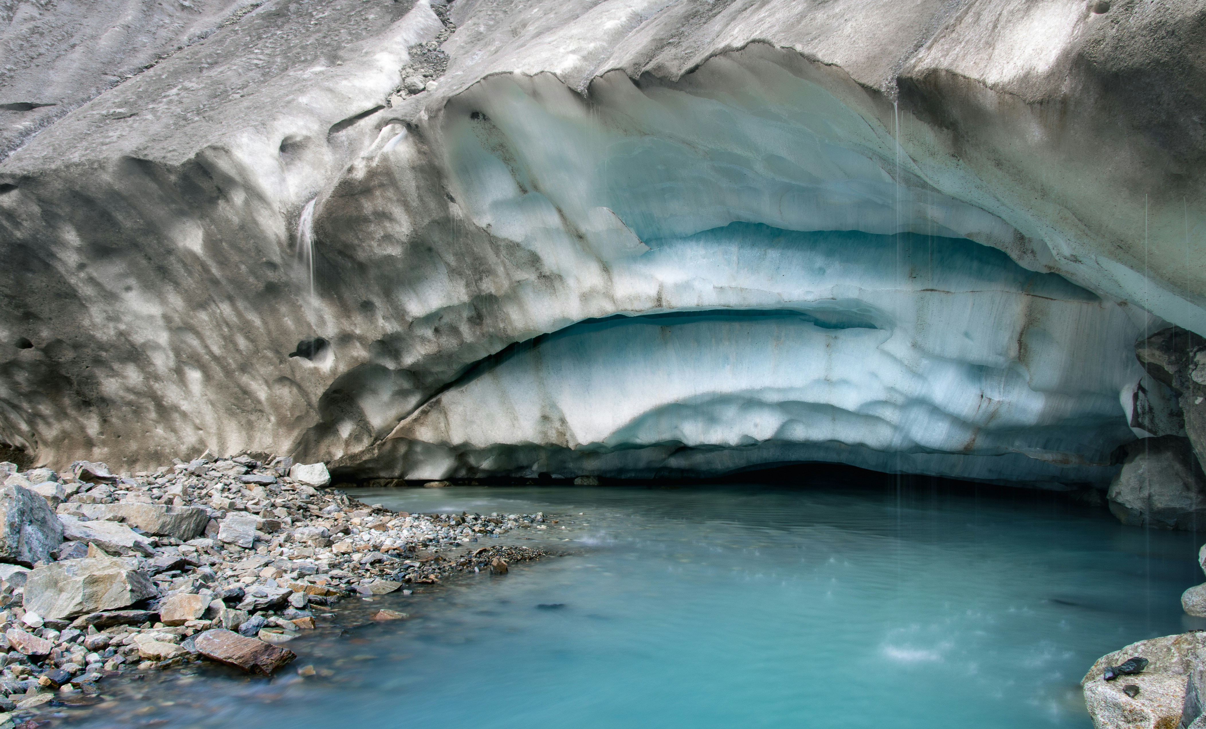 Cerulean Ice Arch Over a Quiet Glacial Pool
