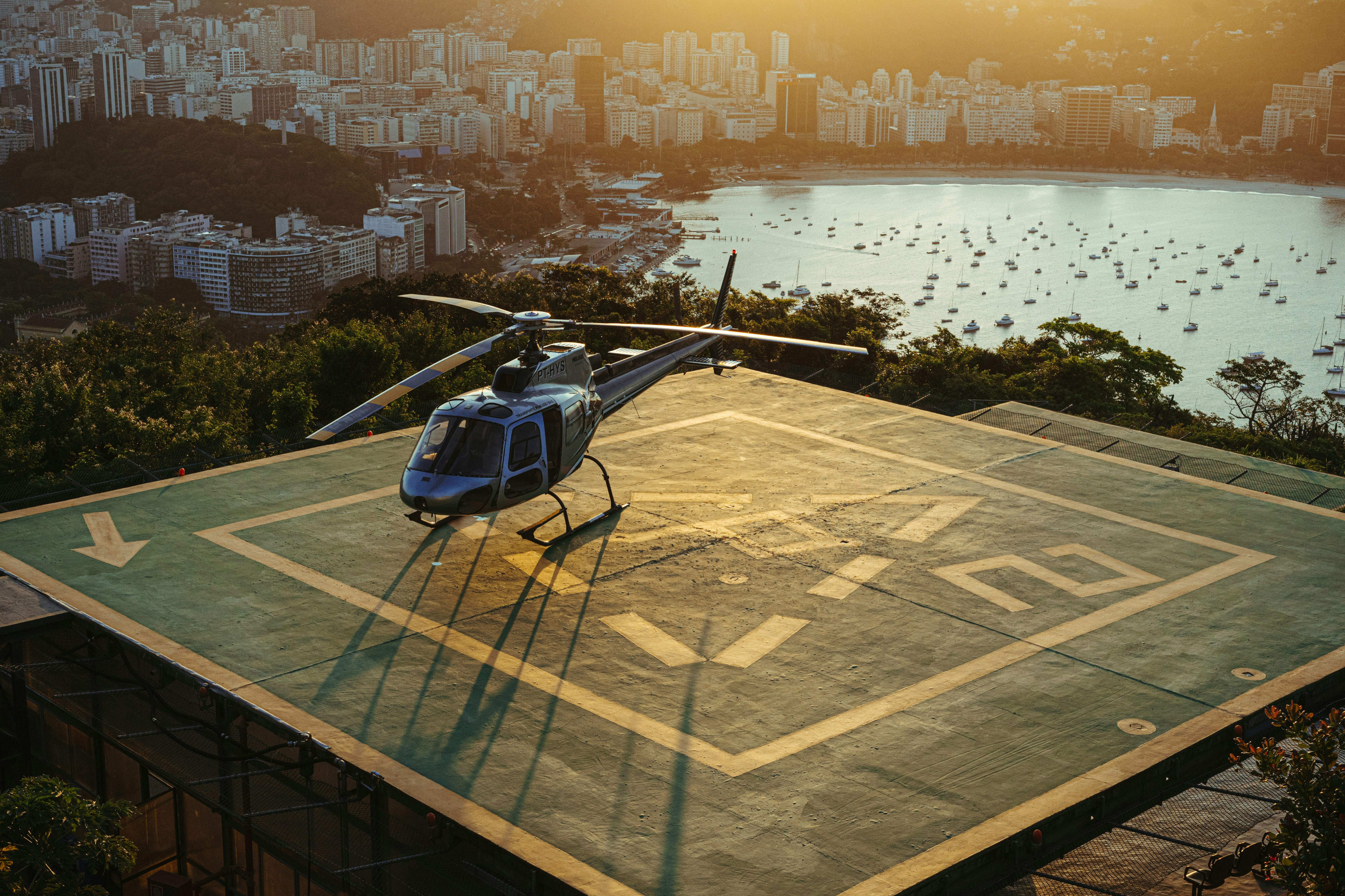 Helicopter on a Sunrise Helipad Over a Coastal City